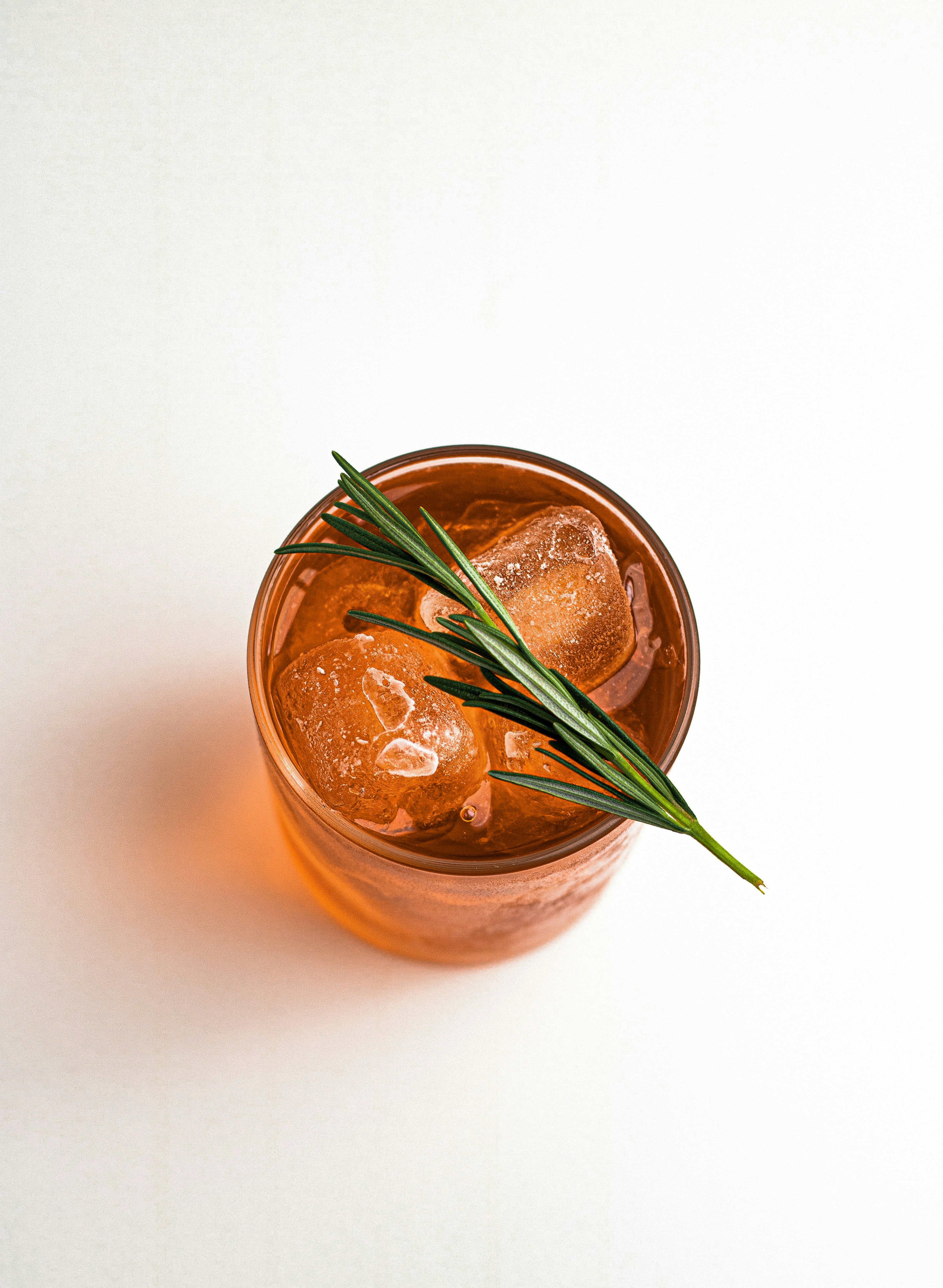 Herbal Ice and Amber Elixir: A Rosemary-Garnished Cocktail Center Stage