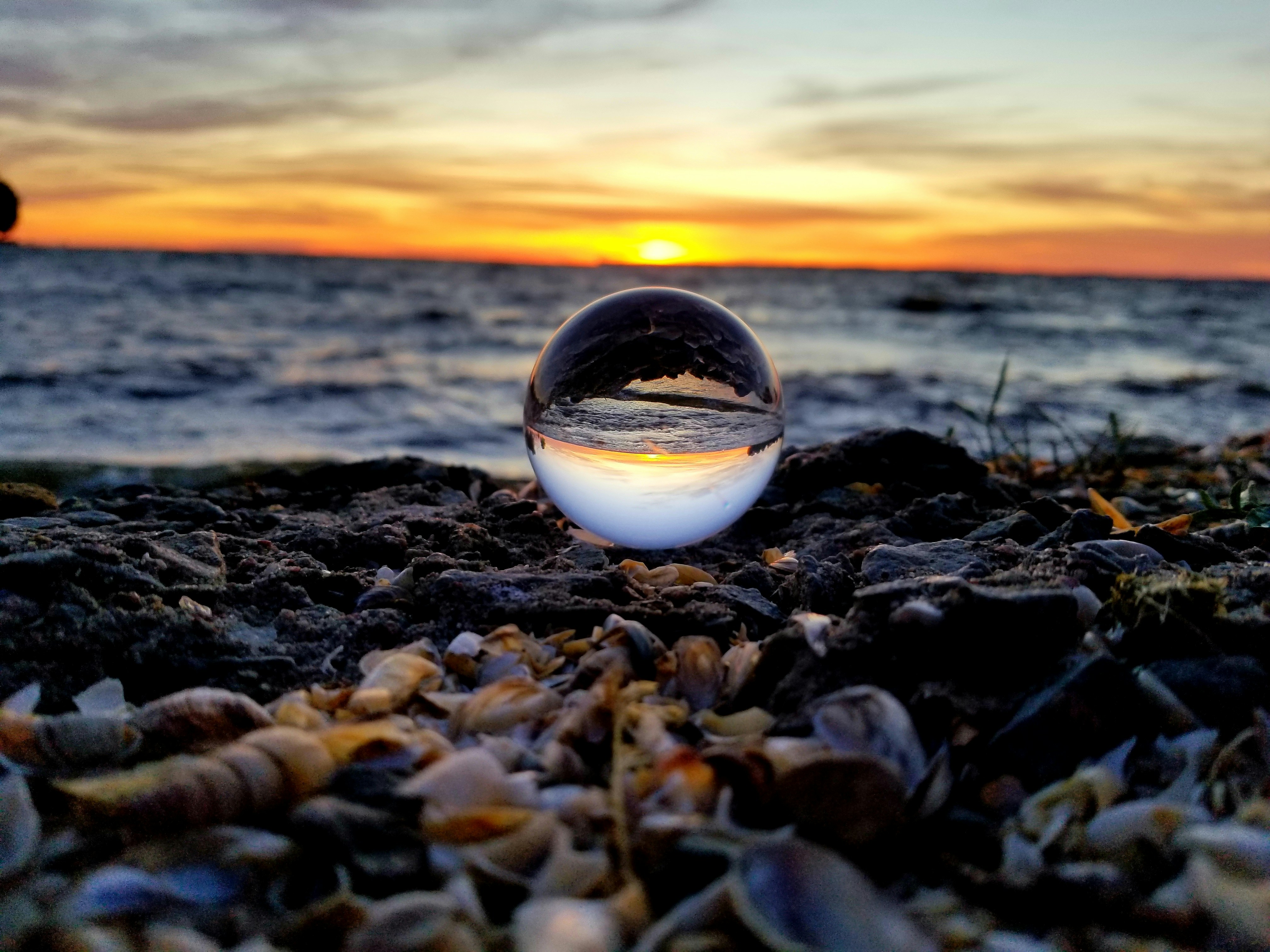 White and black round ball on black and brown rocks during sunset photo ...