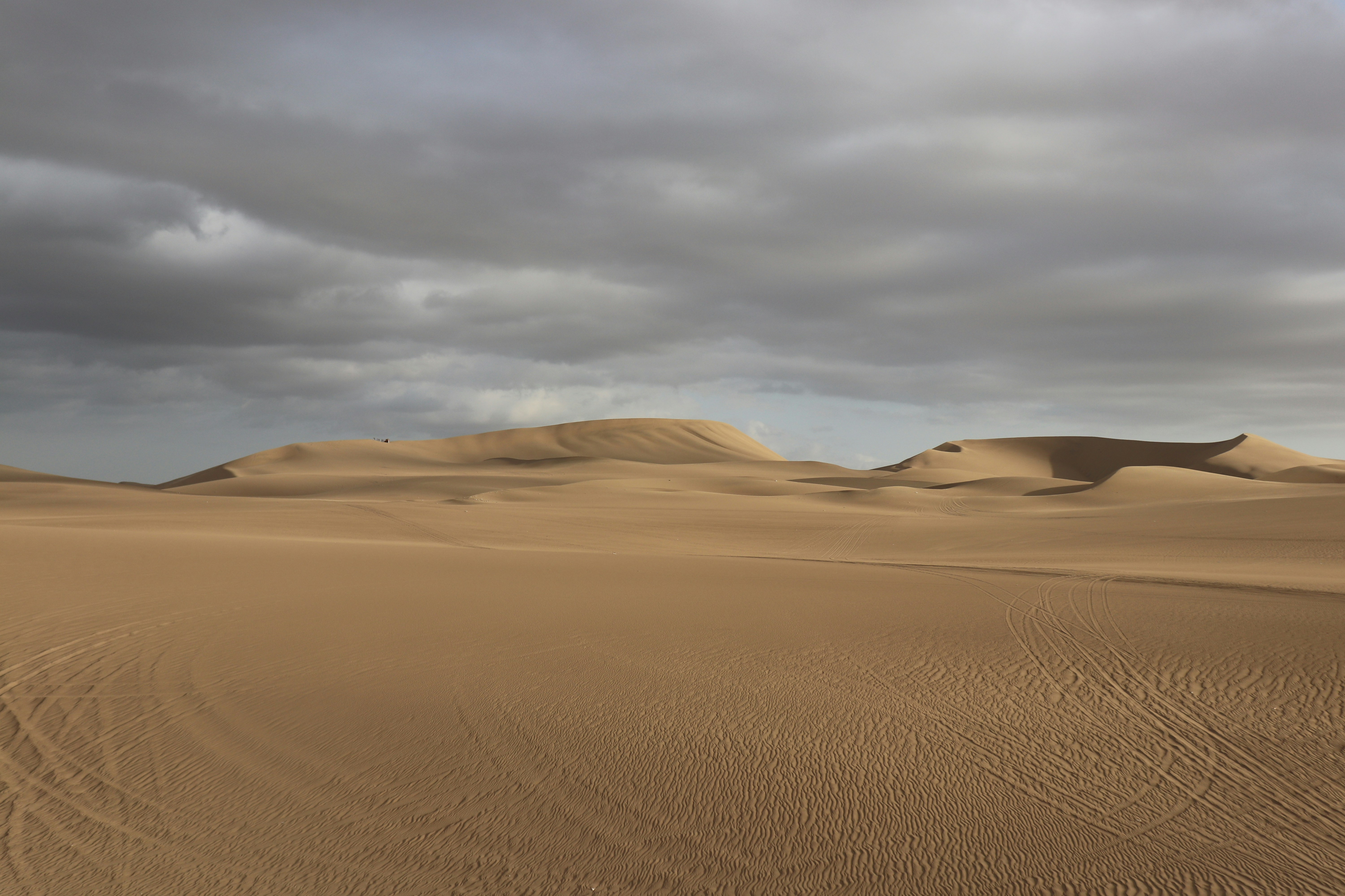 brown sand under white clouds during daytime