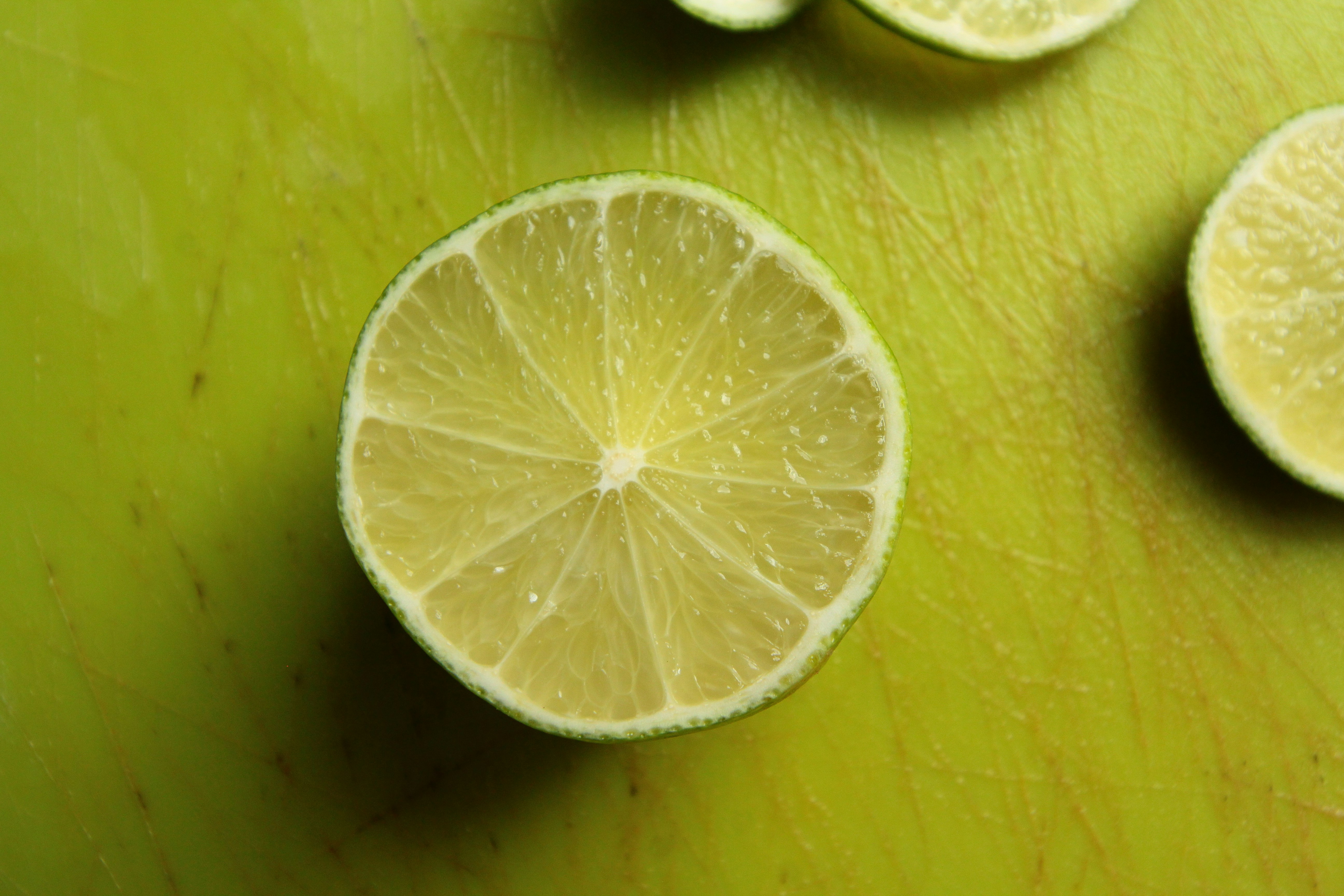 Sliced lime on a green background, showcasing citrus textures and vibrant colors.