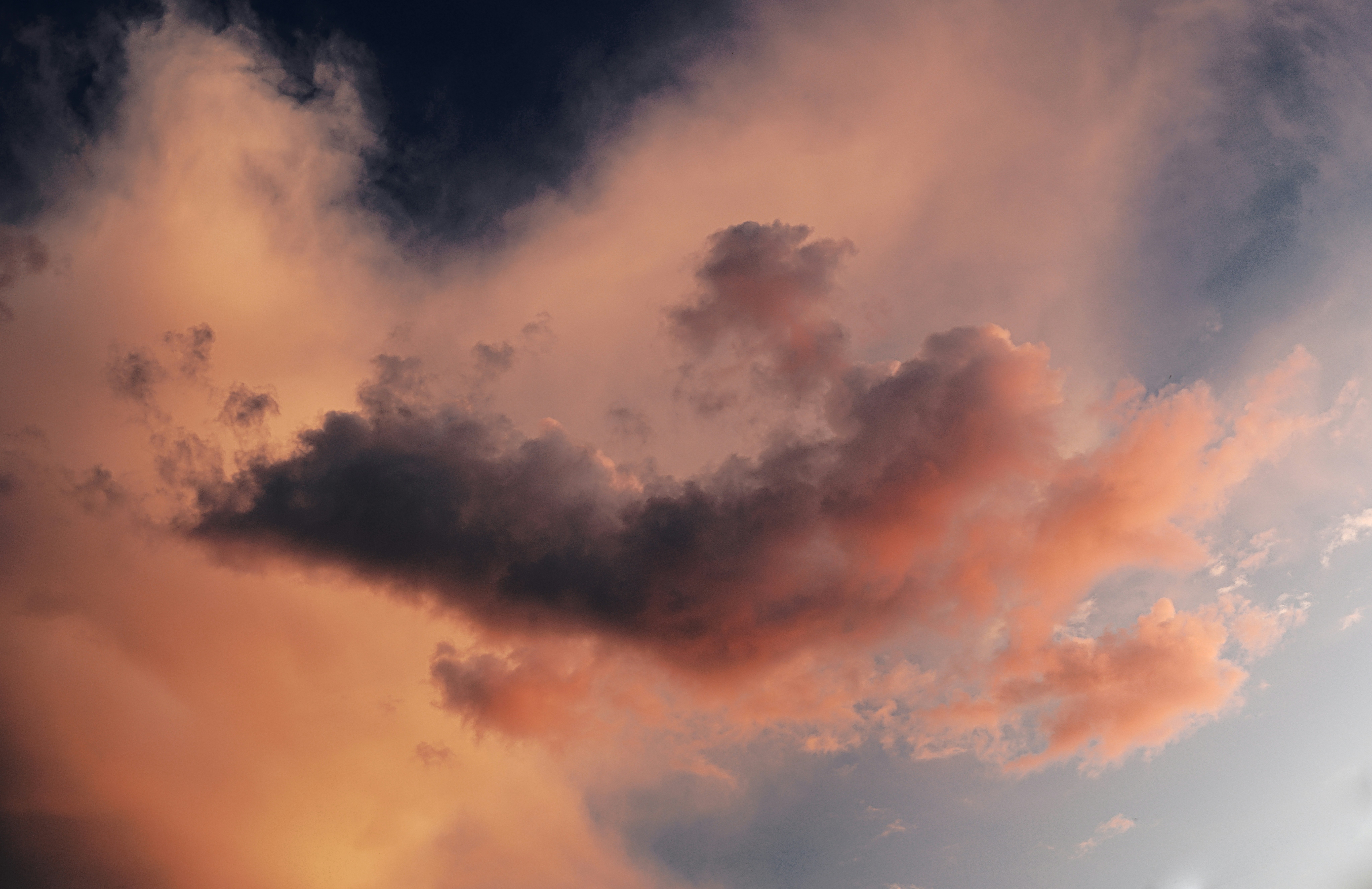 Dramatic clouds with warm sunset hues against a darkening sky.