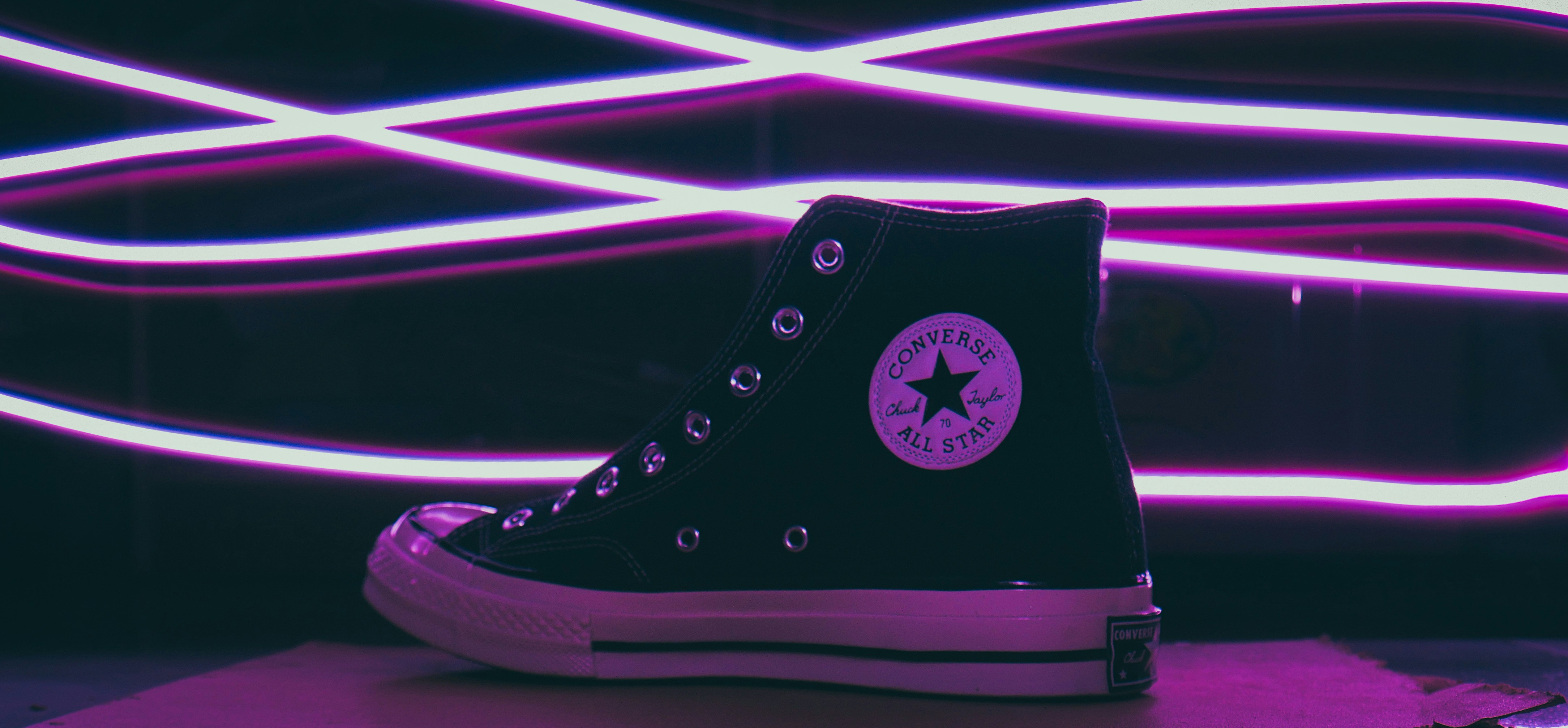 Converse in Neon Ribbons: A solitary sneaker under electric arcs