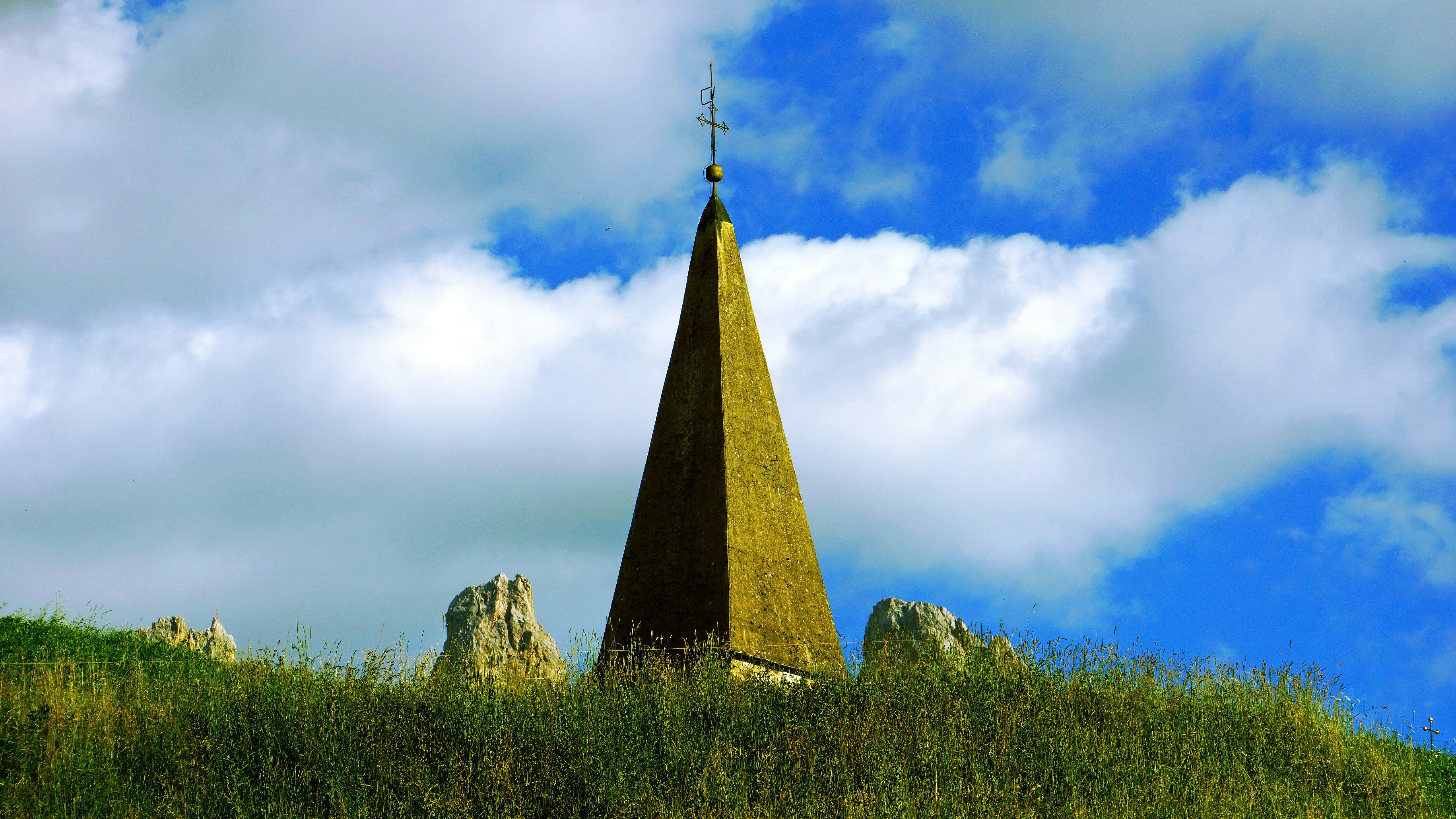 Stone Spire Crowns a Windswept Hill Under a Cobalt Sky
