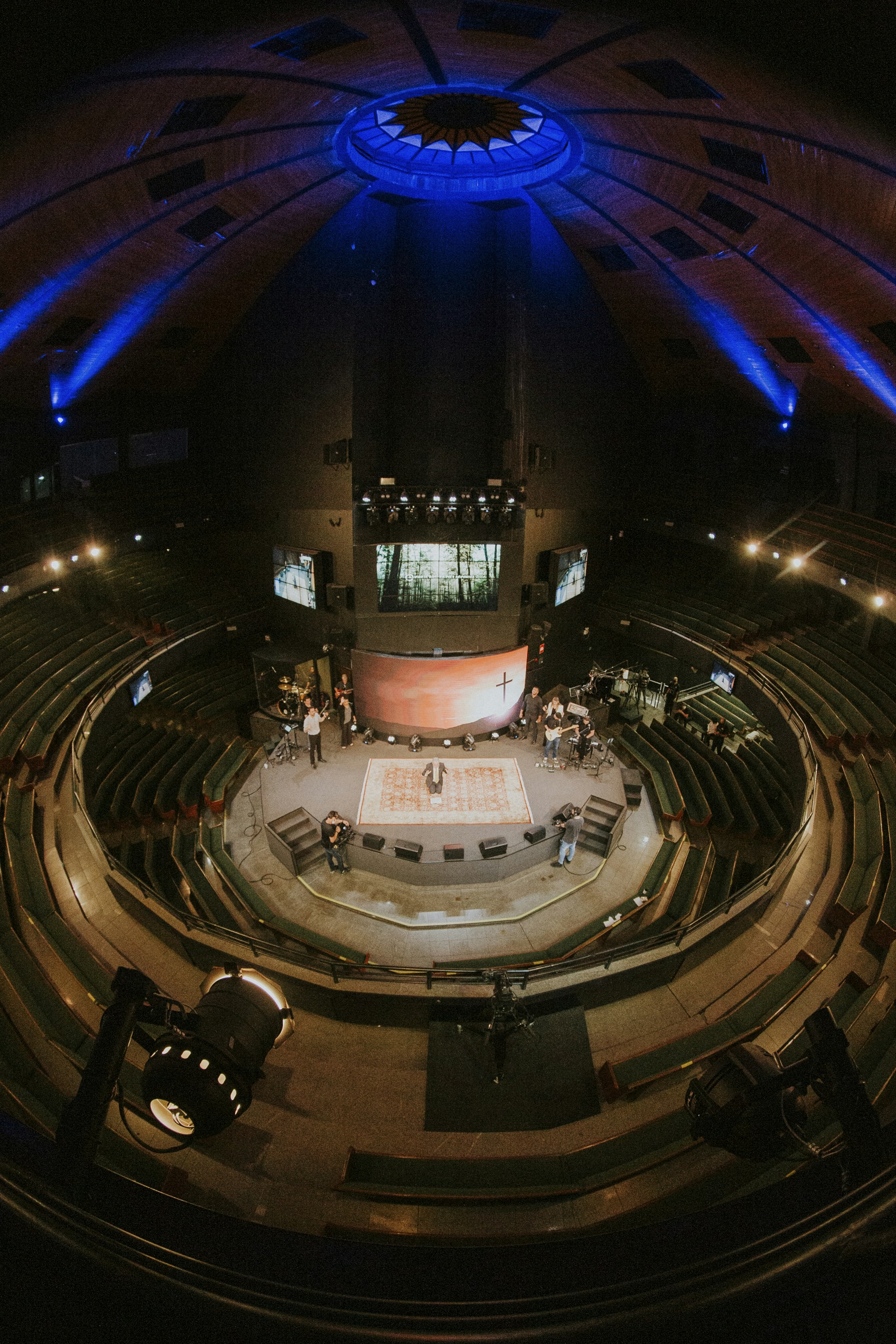Center Stage Under Blue Domed Lights in a Circular Auditorium