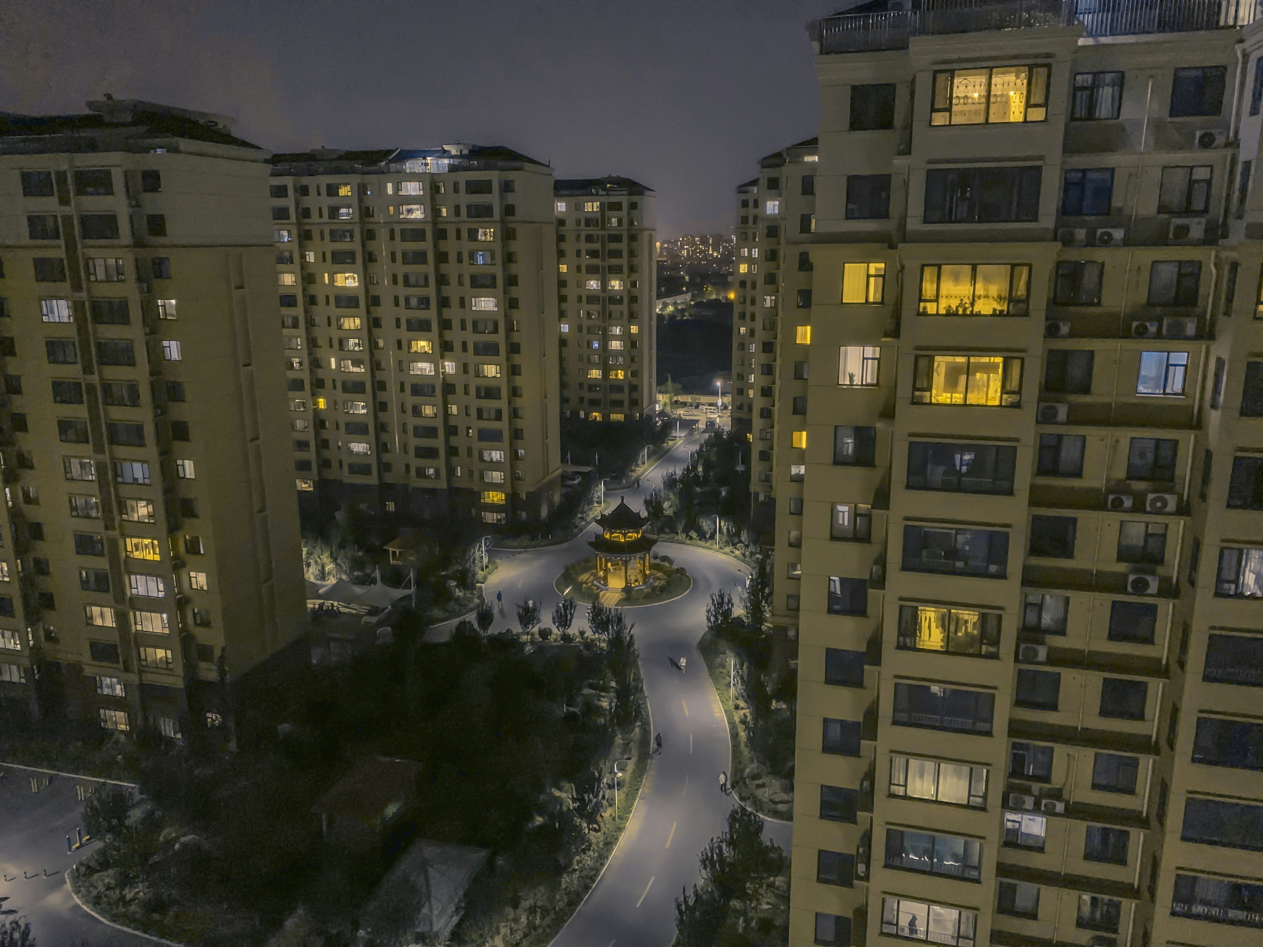 Nighttime Spine: Neon Roundabout Between Tall Towers