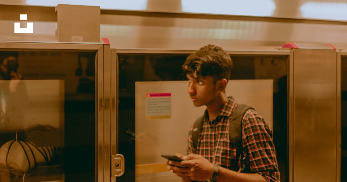 Man In Black And White Plaid Dress Shirt Standing Beside Glass Door