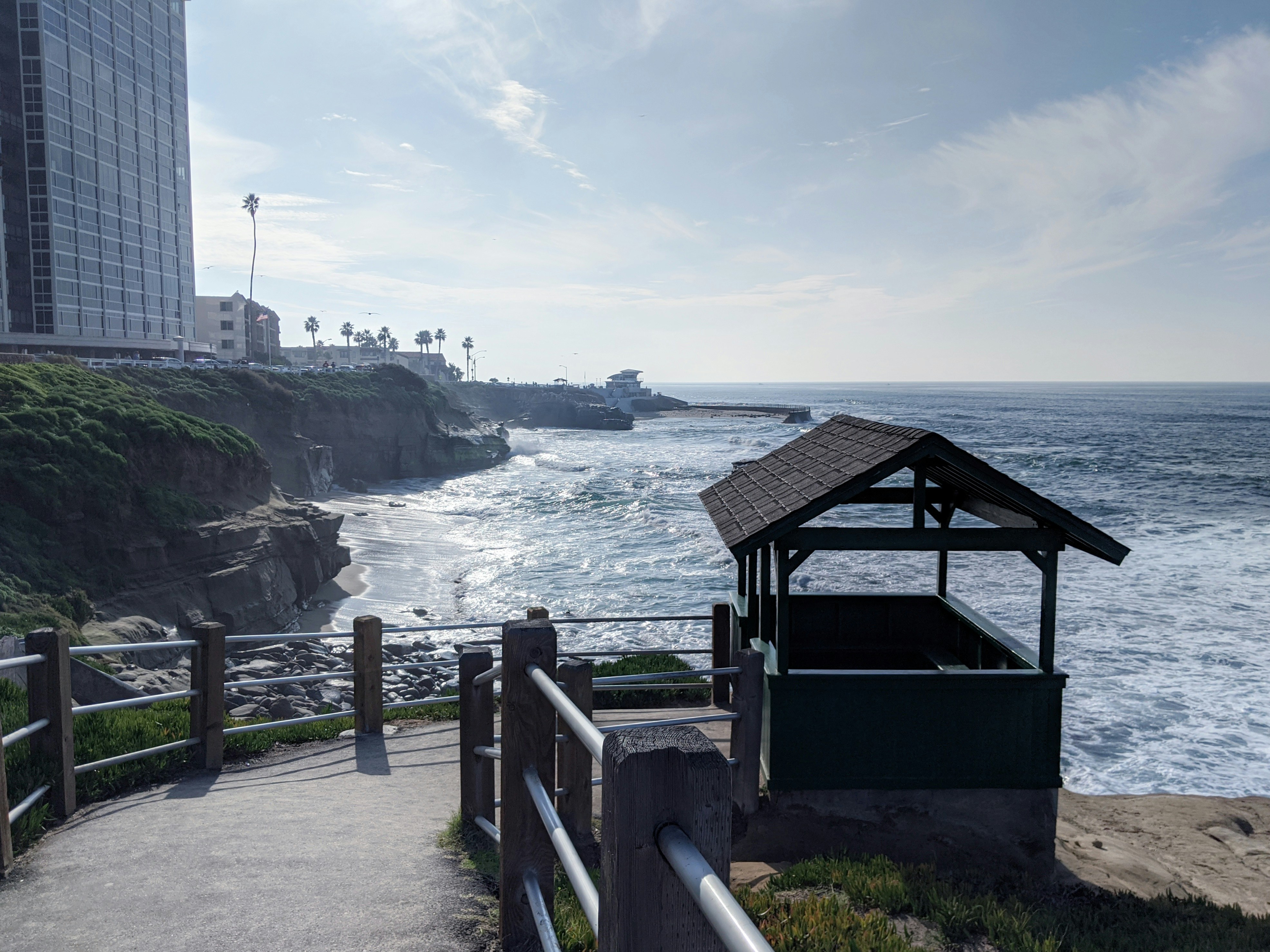Coastal Cliffs and a Shaded Resting Hut by the Surf