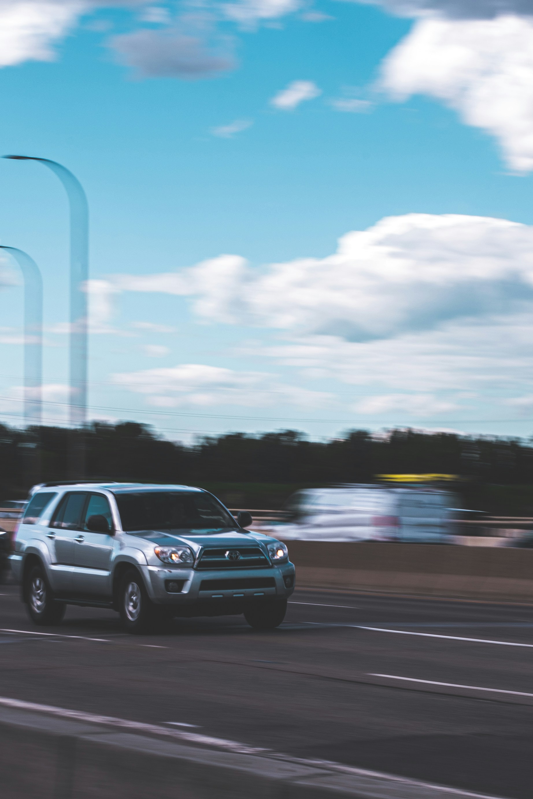 Accelerated Silhouette: Silver SUV on a Blurred Highway