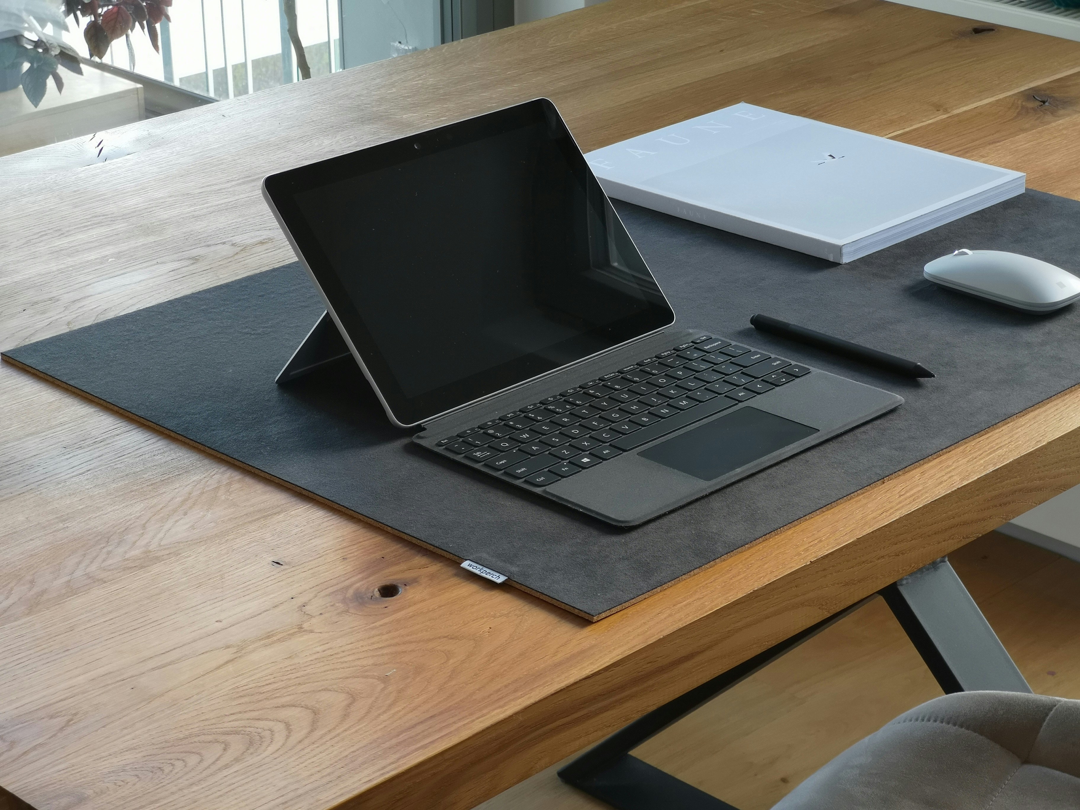 Sleek tablet with keyboard and accessories arranged neatly on a stylish desk, emphasizing a minimalist workspace aesthetic.