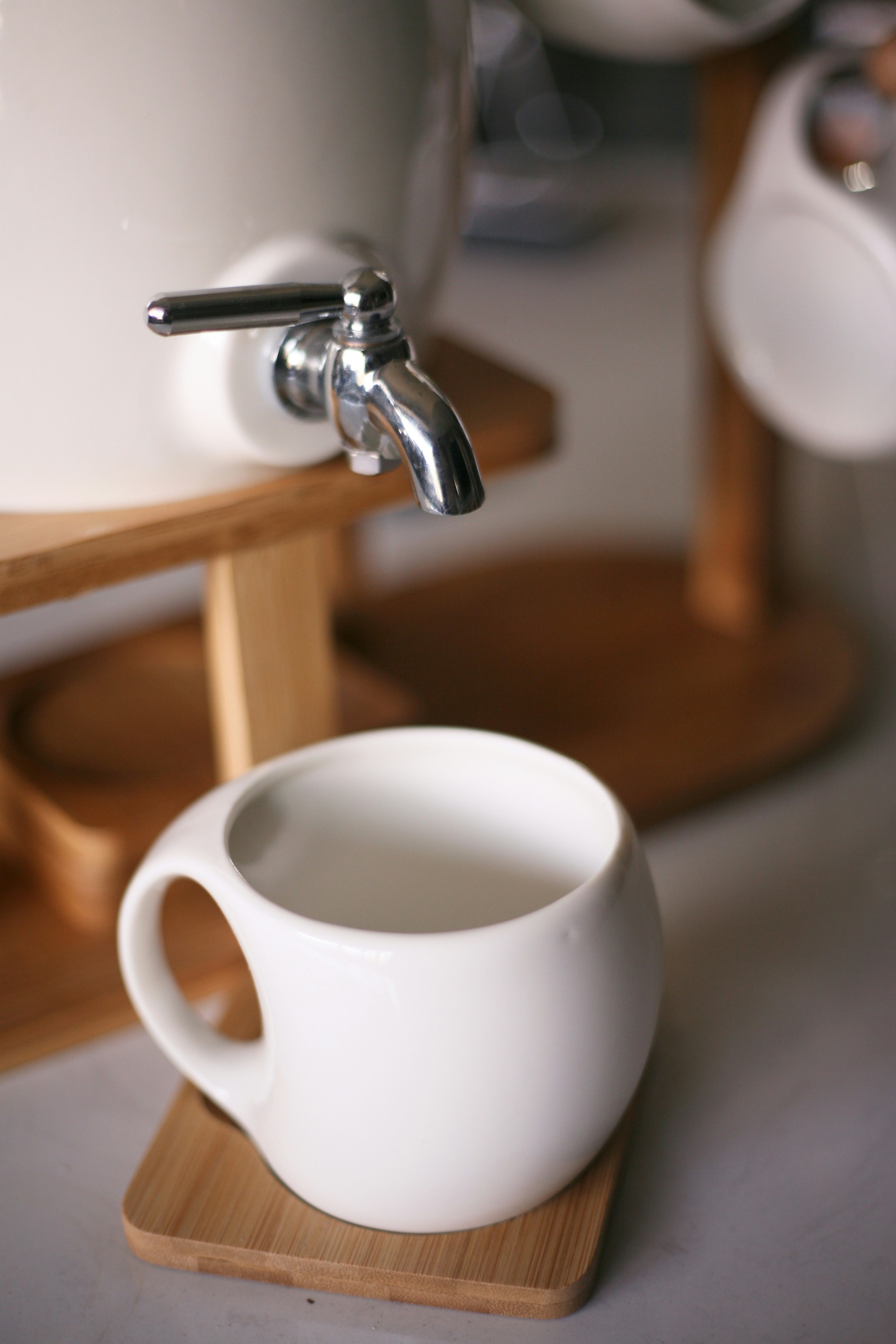 Chrome Tap Above a Solo White Cup: A Quiet Kitchen Moment