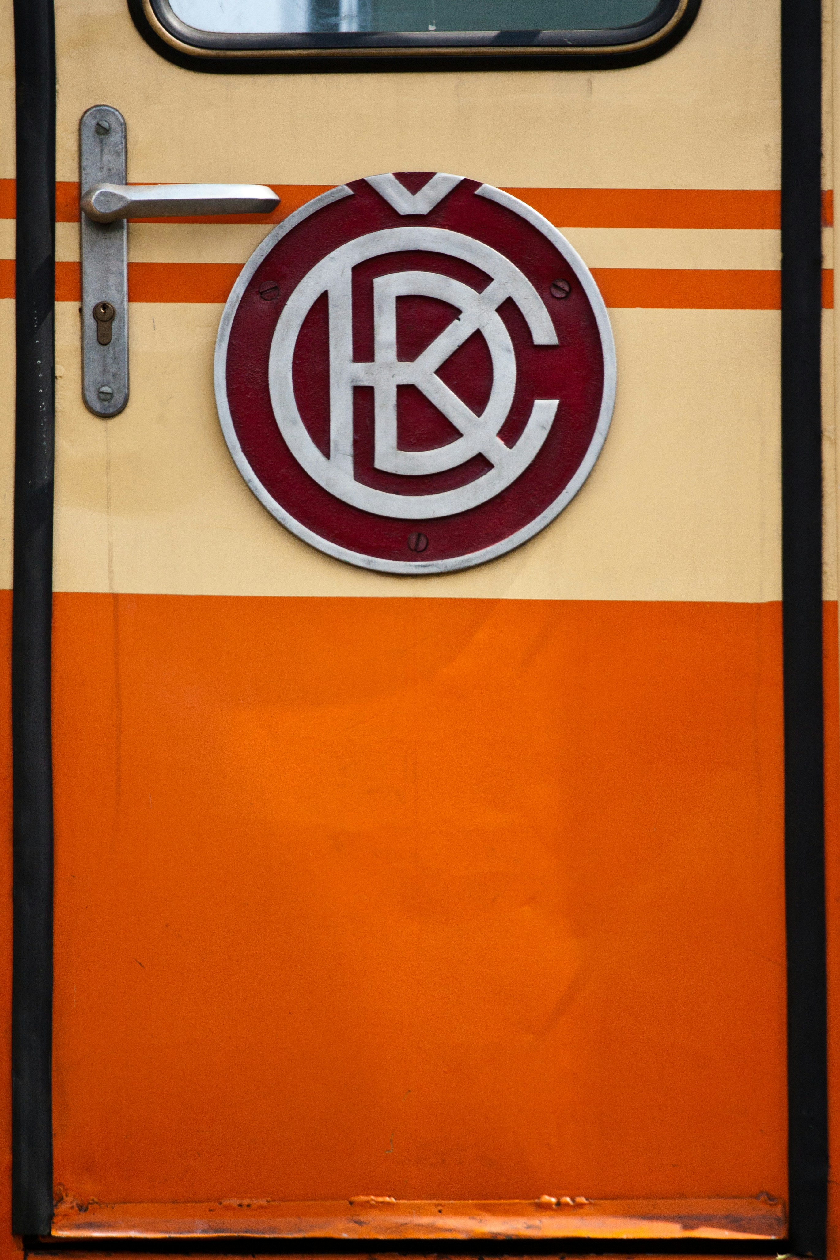 Emblem in Orange and Cream: A Close-Up of a Train Door Crest