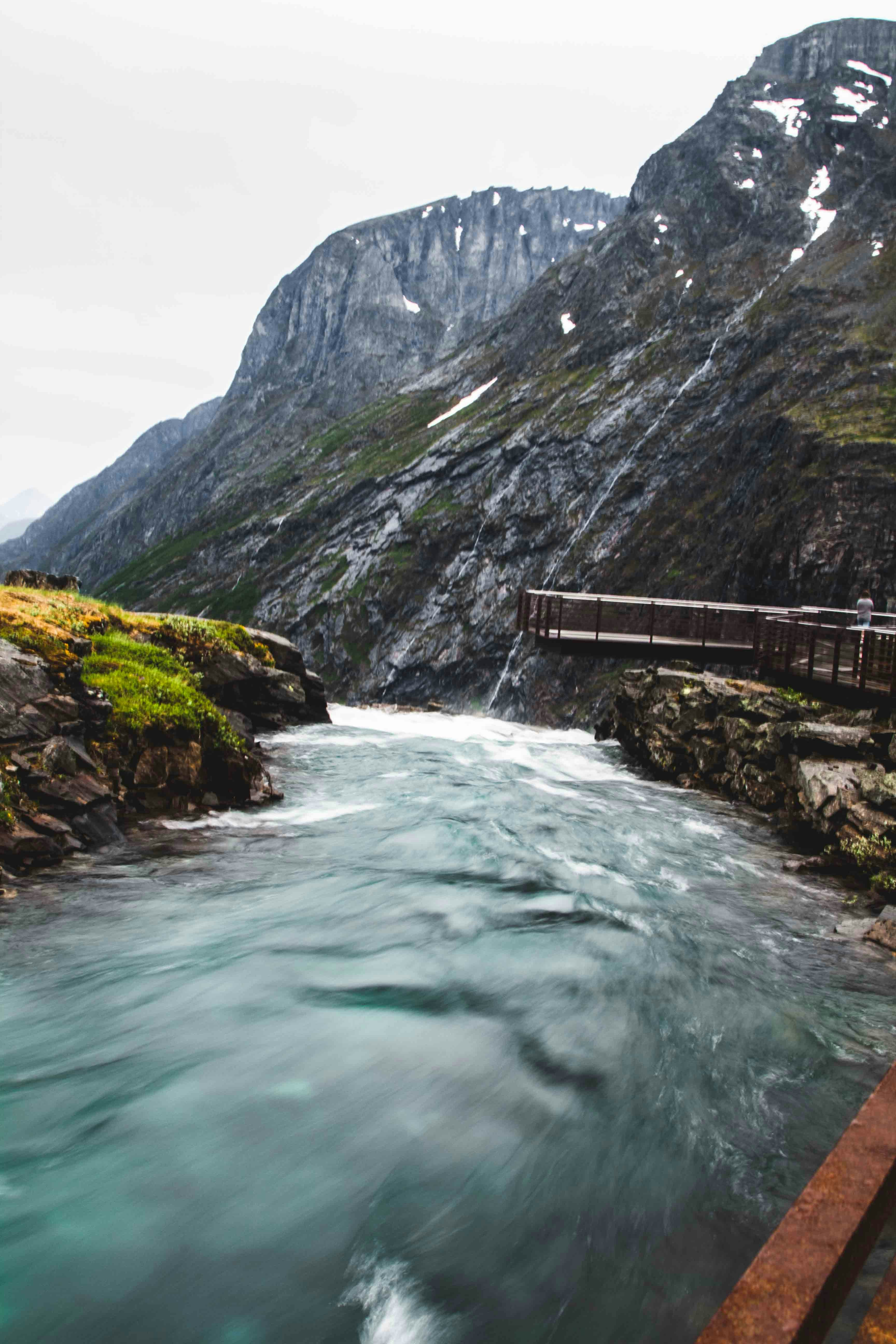 Turquoise Torrent Beneath a Cliffside Bridge.