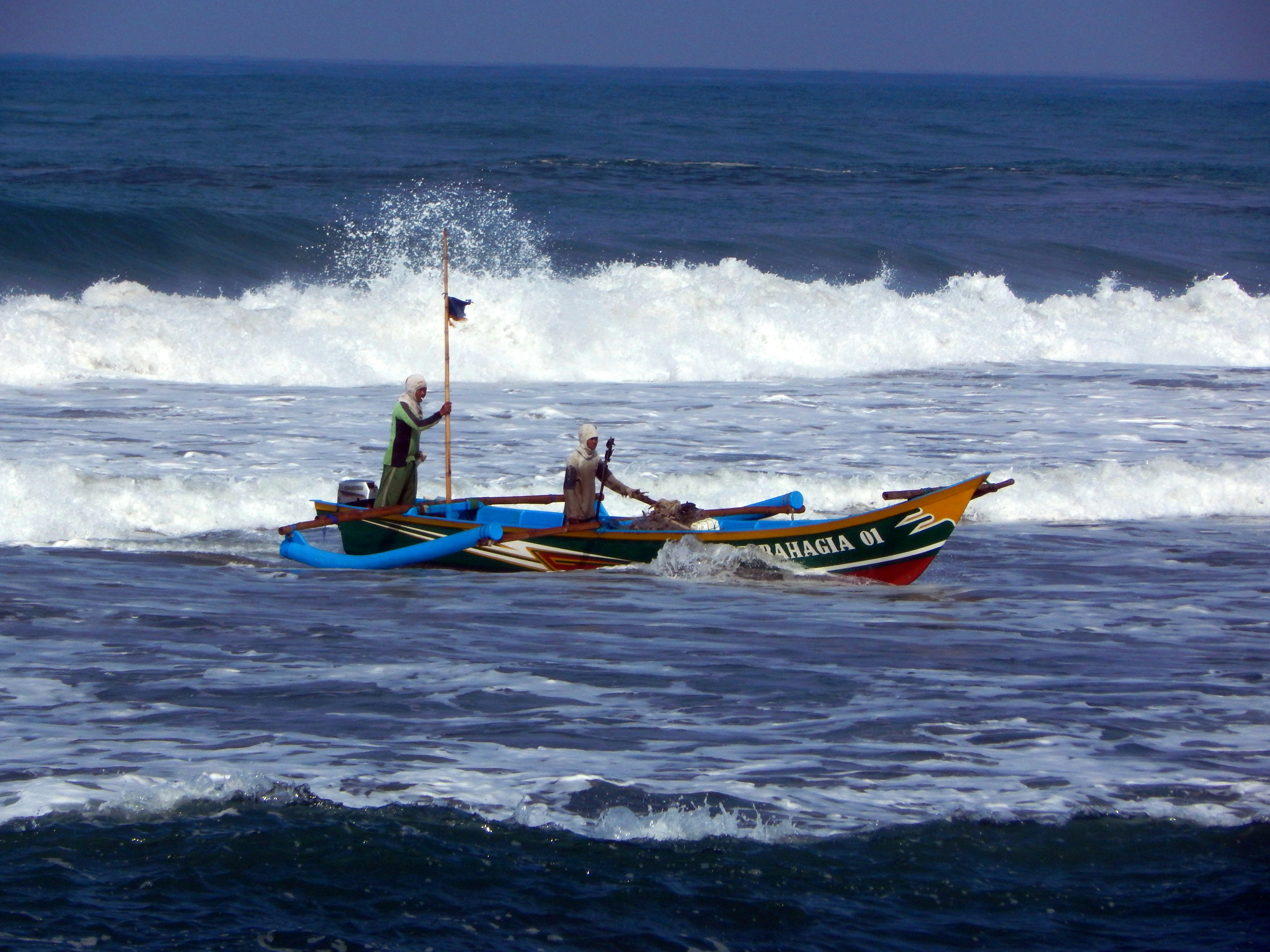 man riding on red and blue boat on sea during daytime