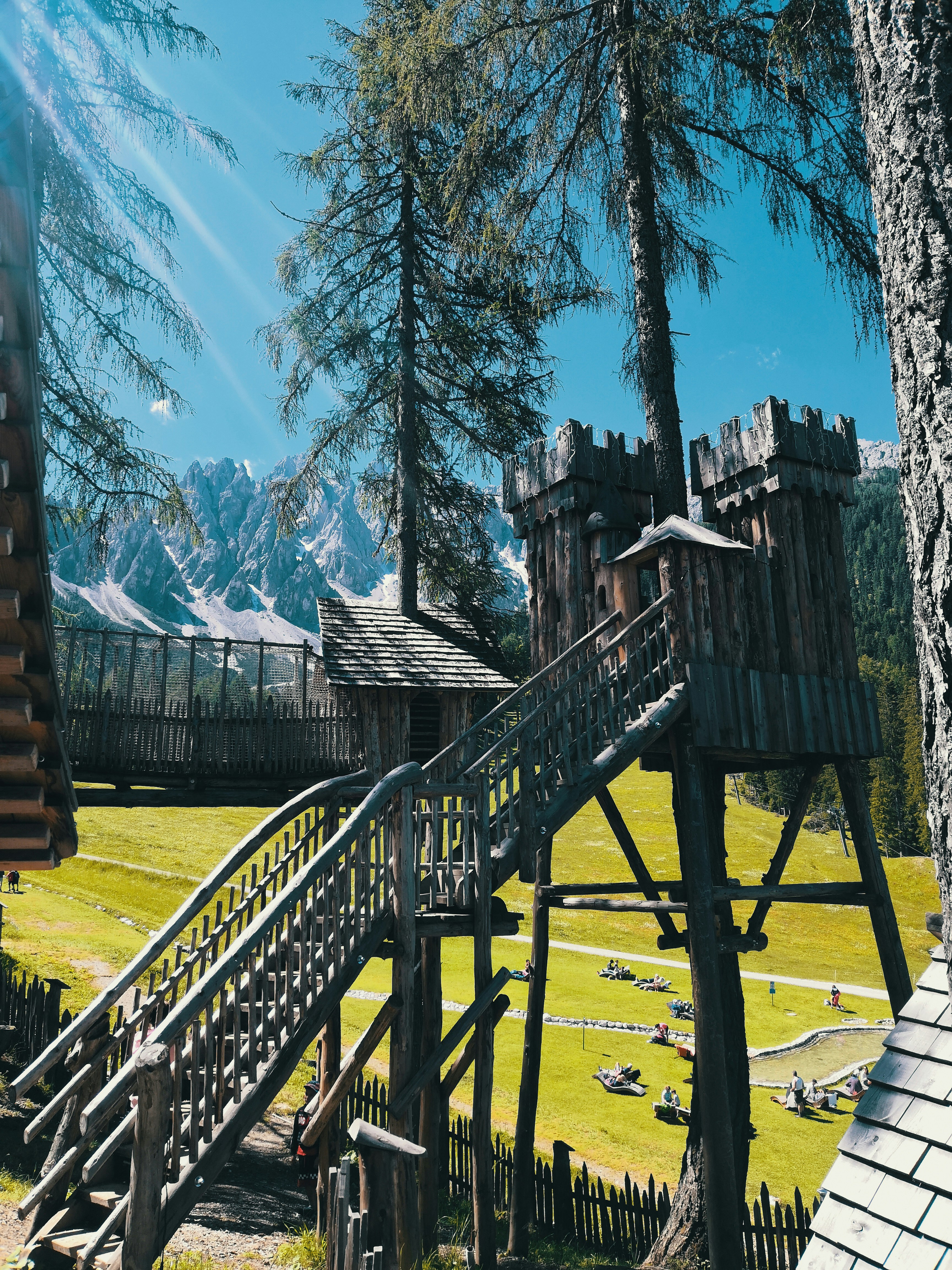 Alpine Fortress: A Sunlit Wooden Playground Framed by Pines