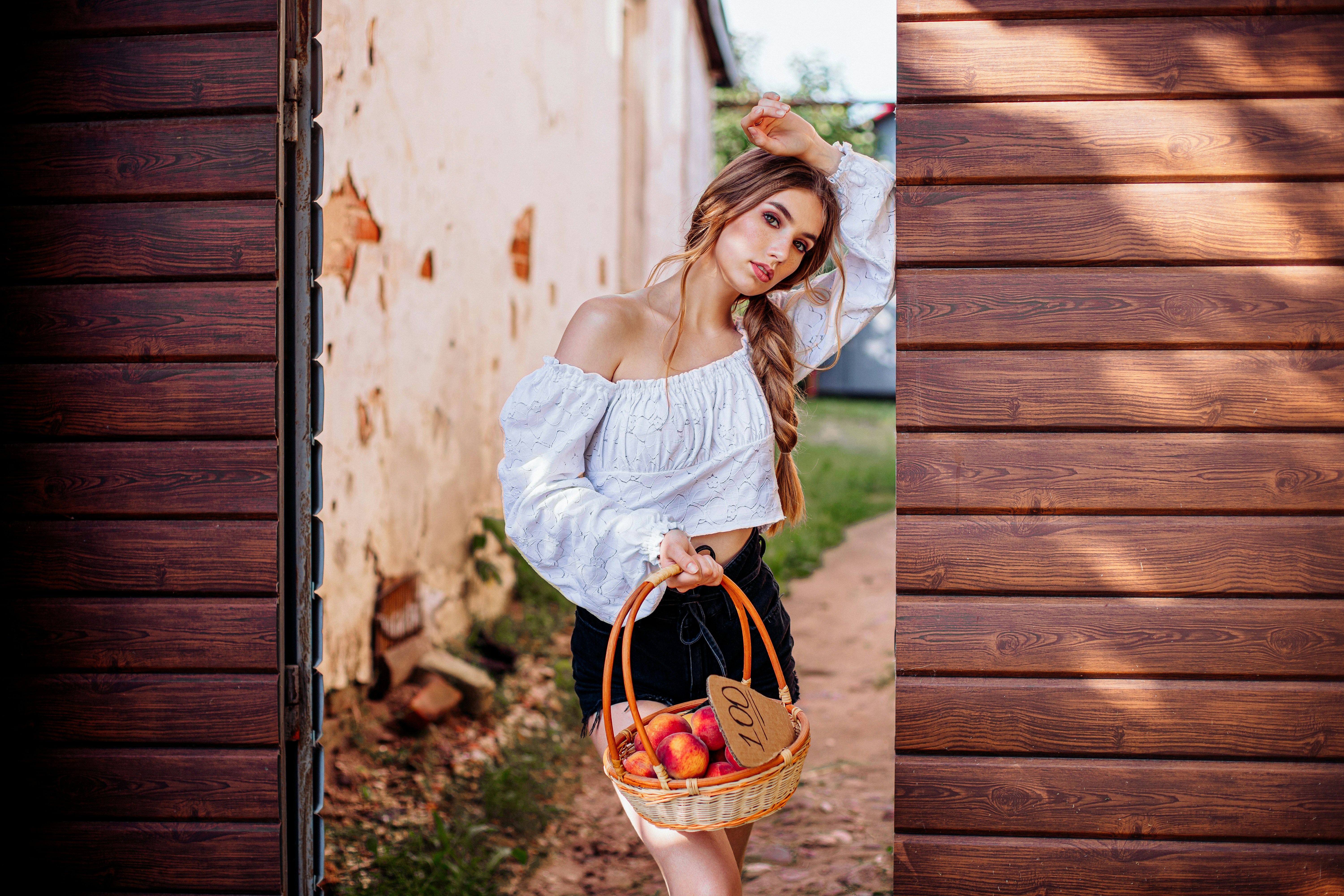 Sunlit doorway portrait: a wicker basket of apples and a confident gaze