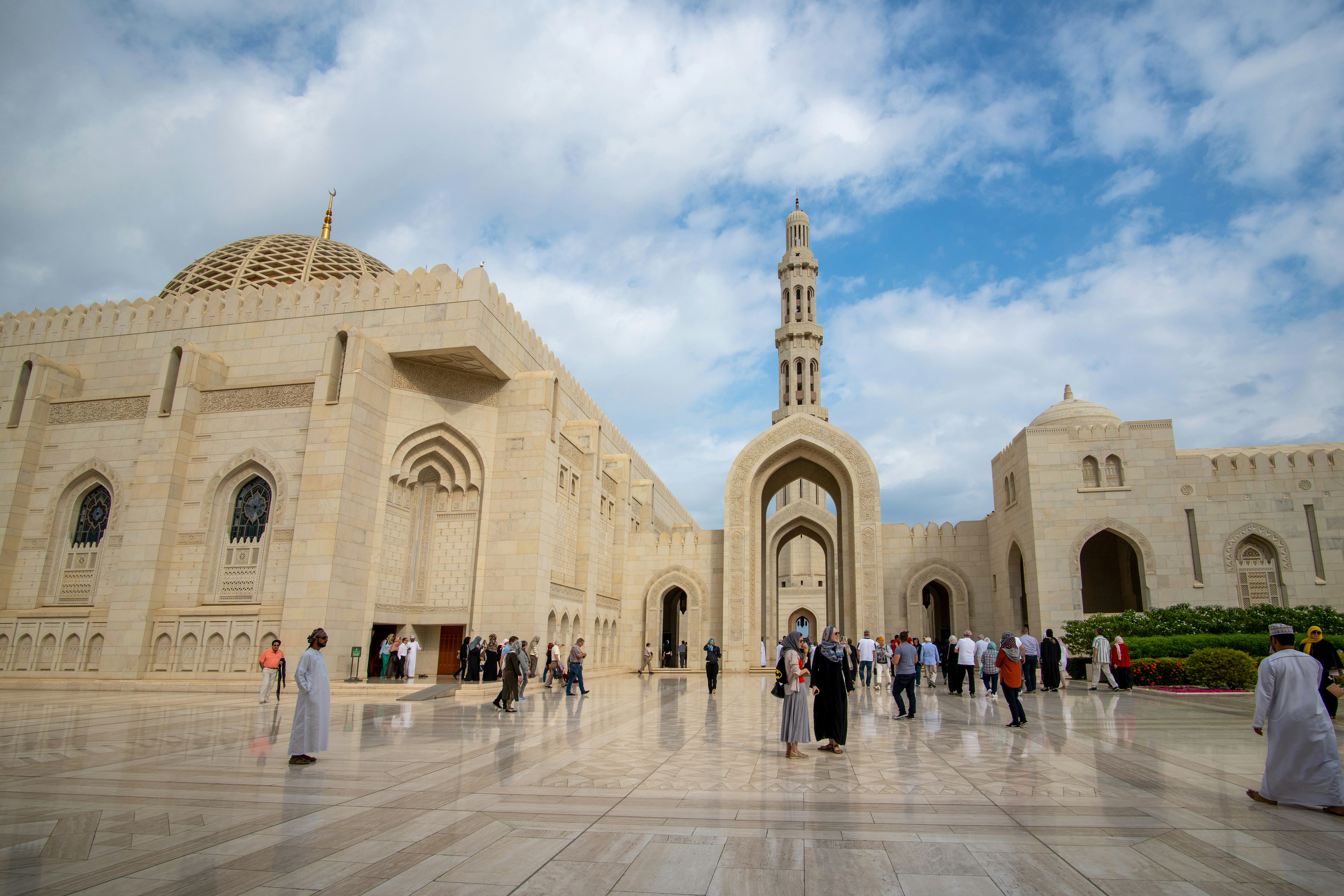 Sultan Qaboos Mosque in Muscat, Oman | people walking near beige concrete building during daytime