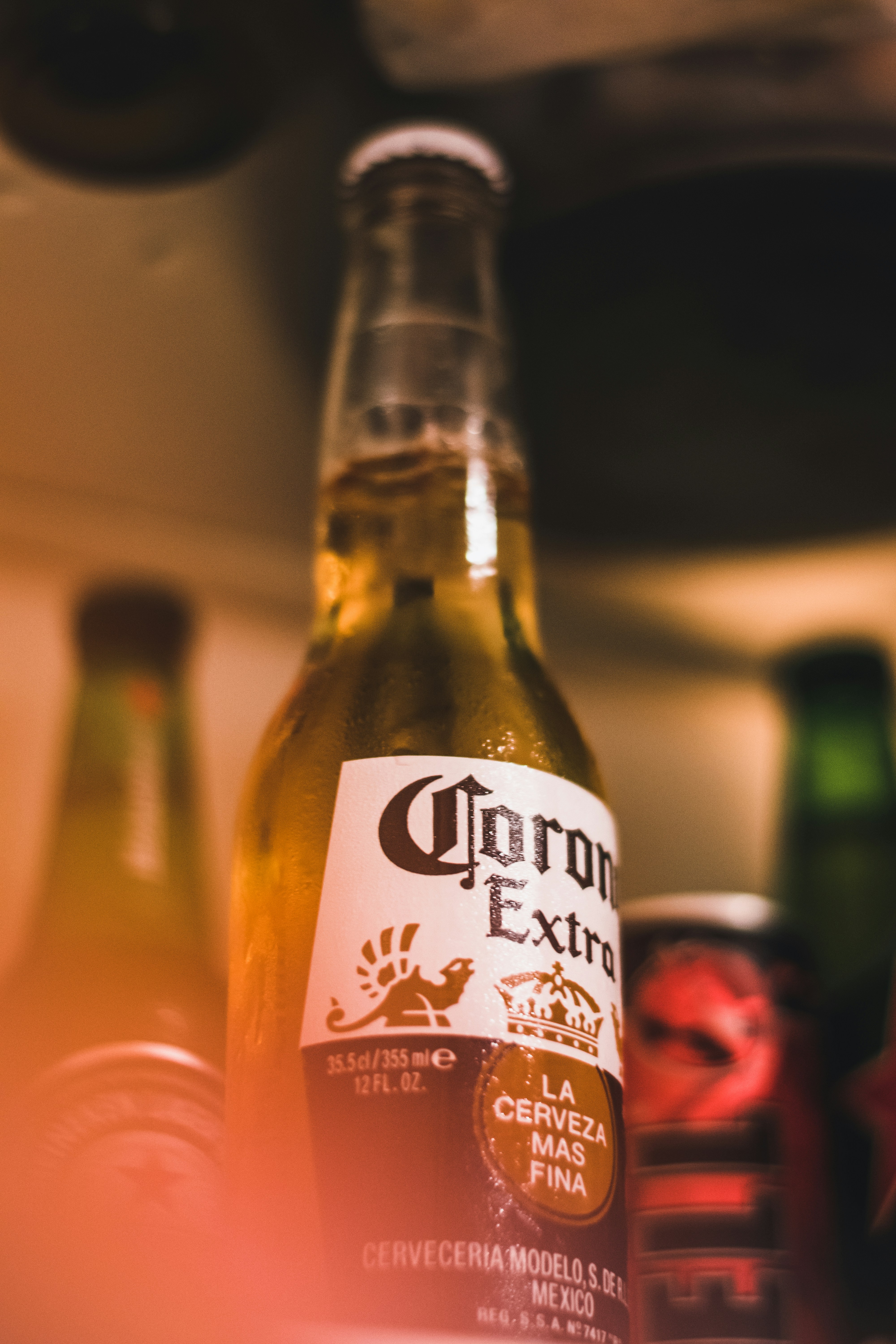 Amber Glow: a Corona bottle under bar lights with a softly blurred backdrop