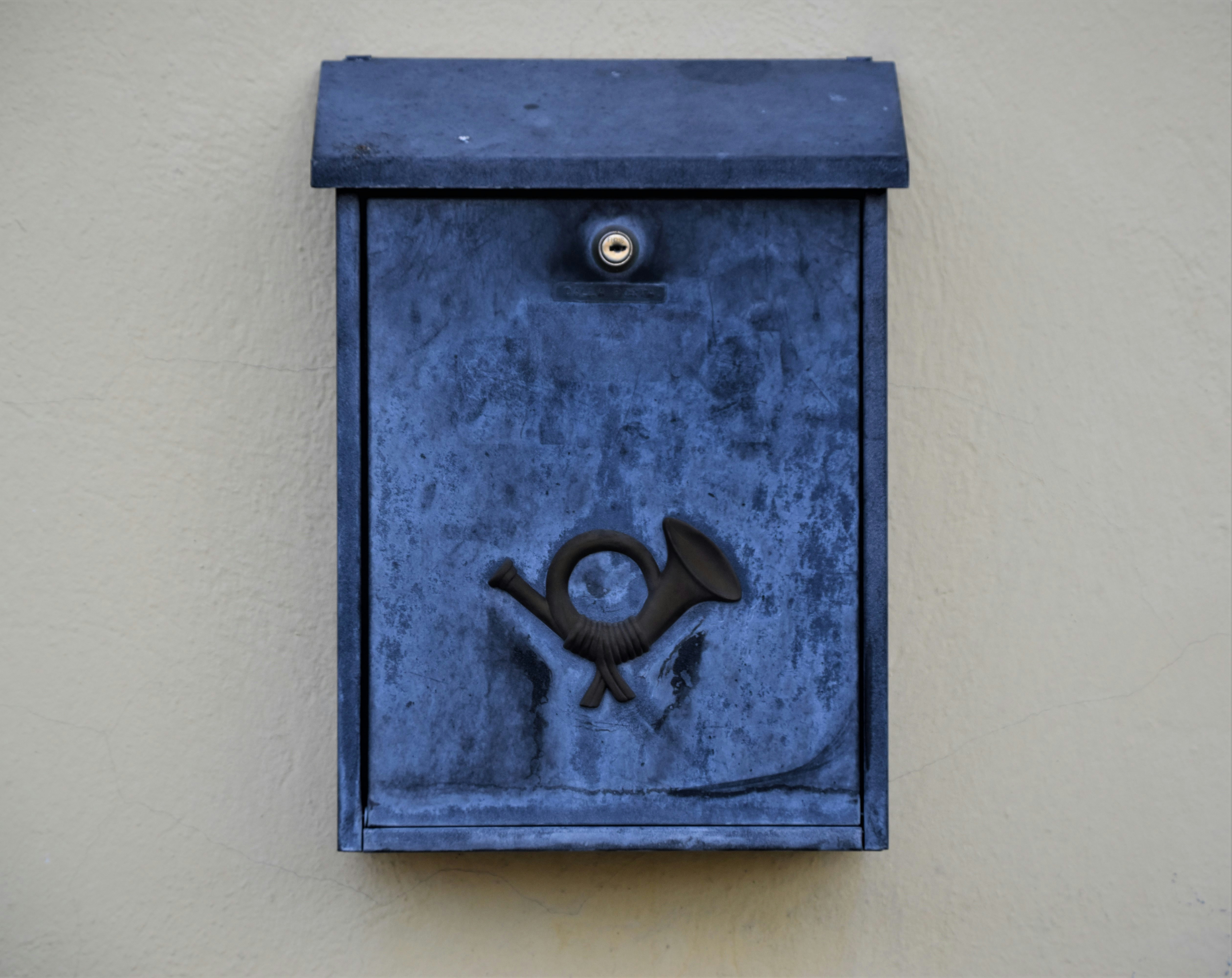 a blue colorful mailbox | blue wooden door with black steel door lever