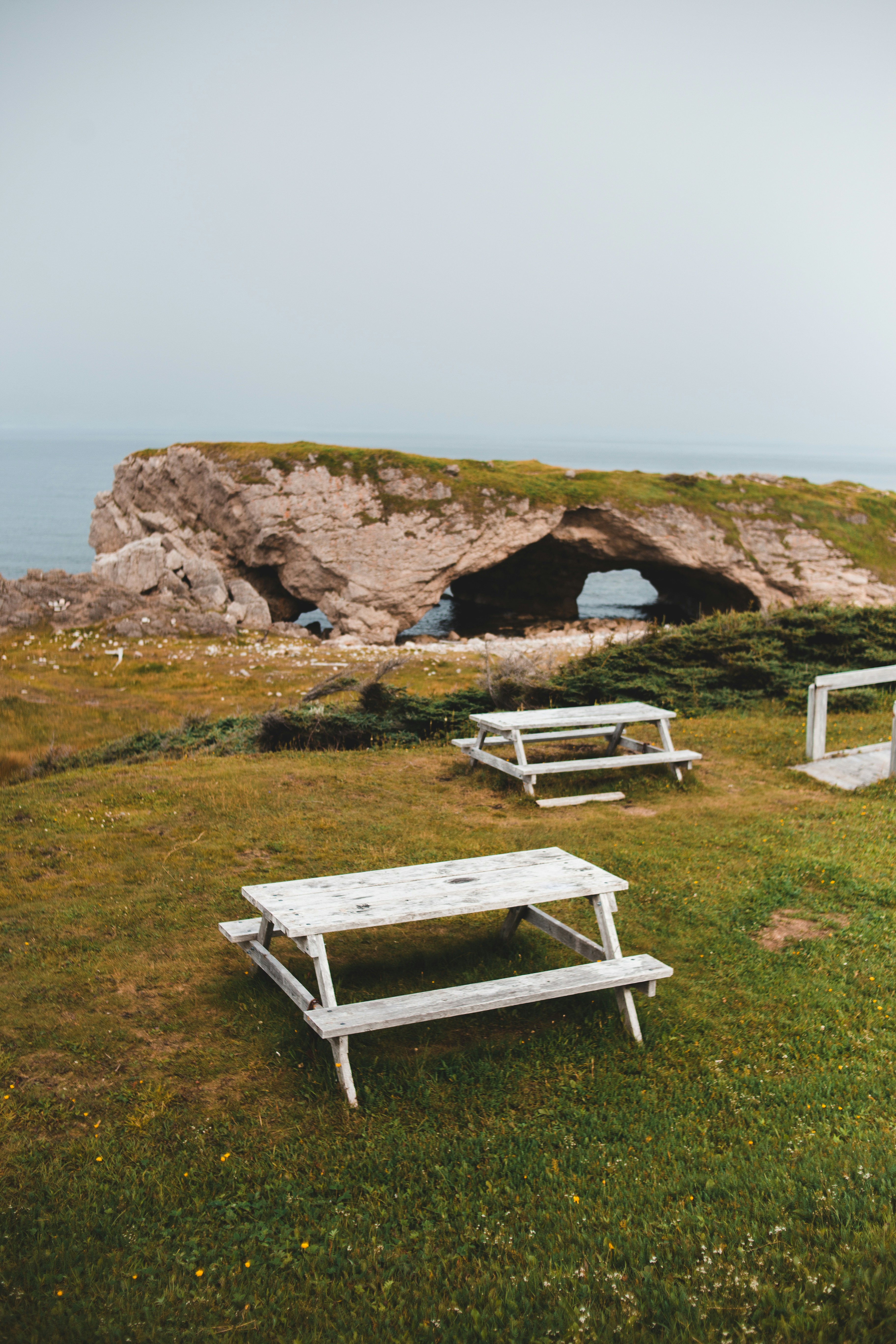 Weathered Coastal Arch Over a Quiet Picnic Field by the Sea