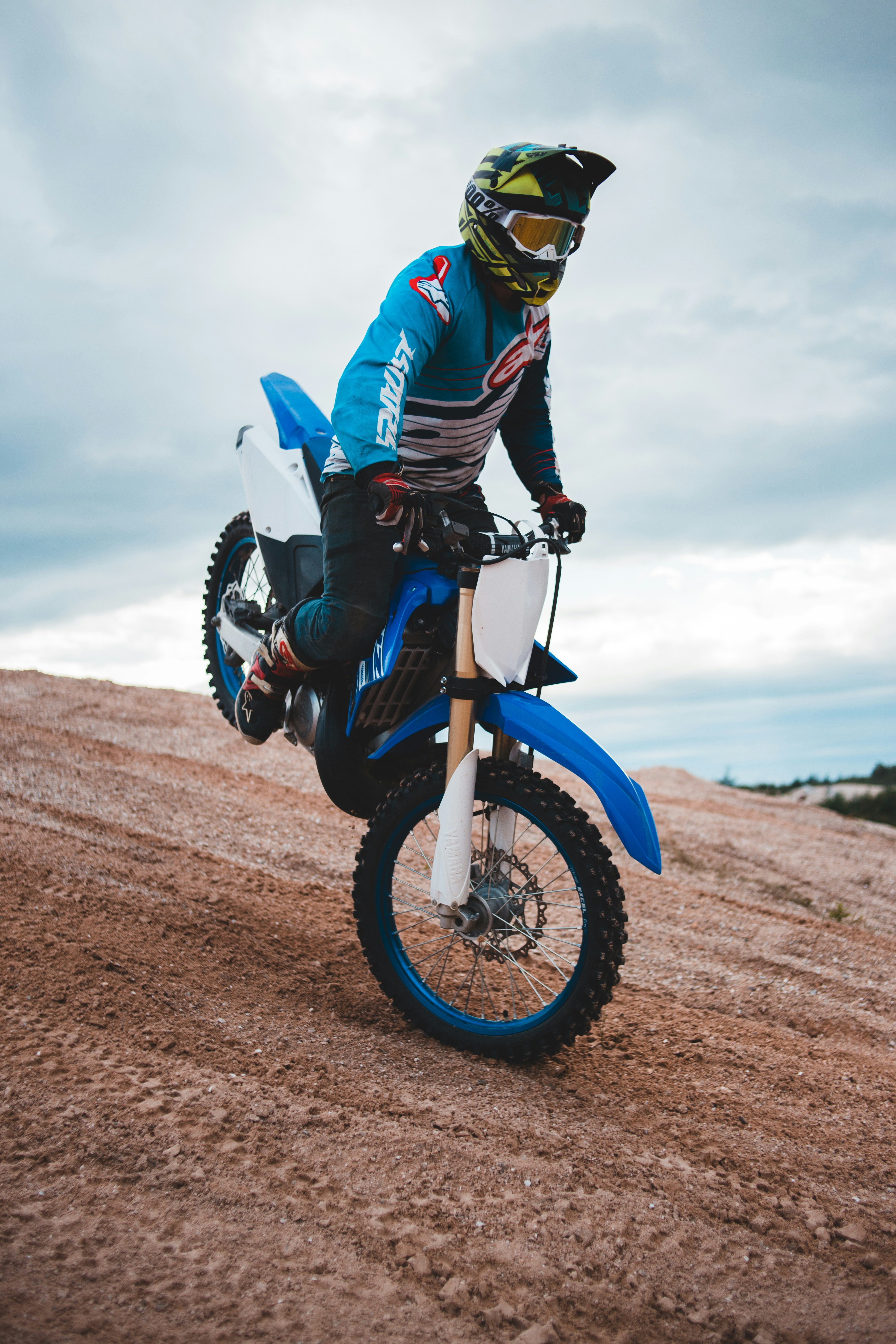Foto Hombre en traje de motocross azul y blanco montando motocross ...
