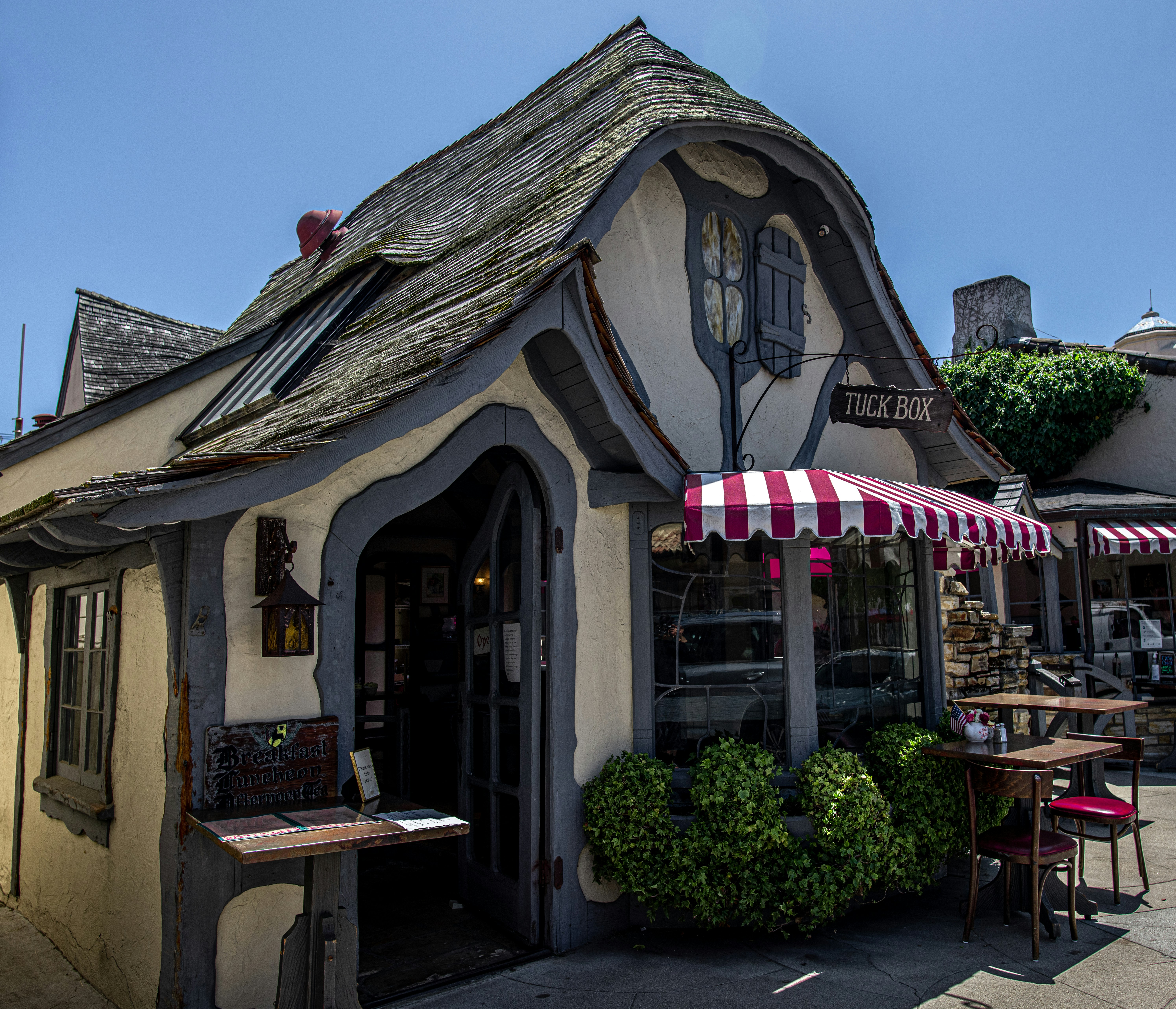 Thatched-Roof Café with a Striped Veranda by a Sunlit Street