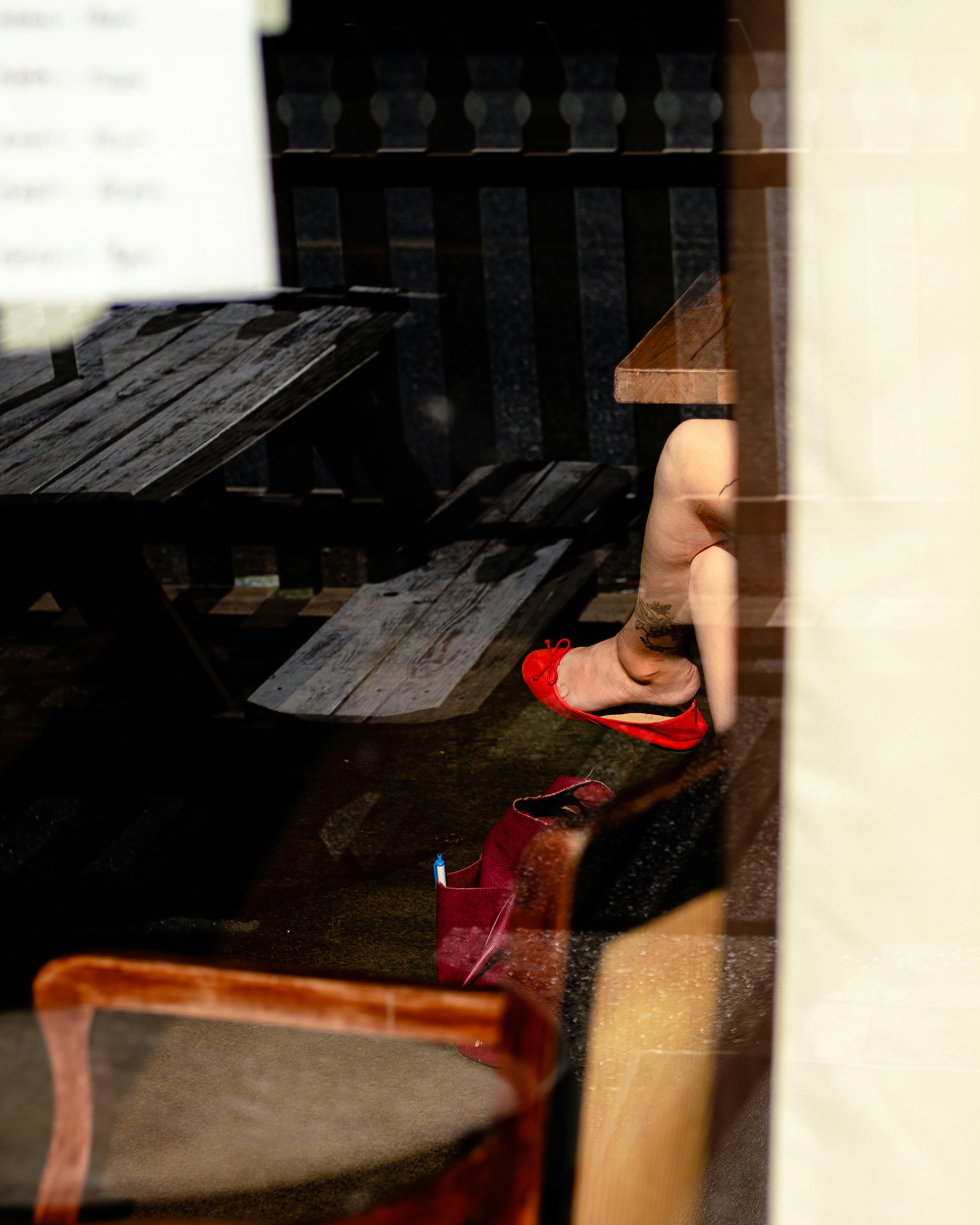 Glass Reflections: Red Flip-Flops on a Weathered Deck