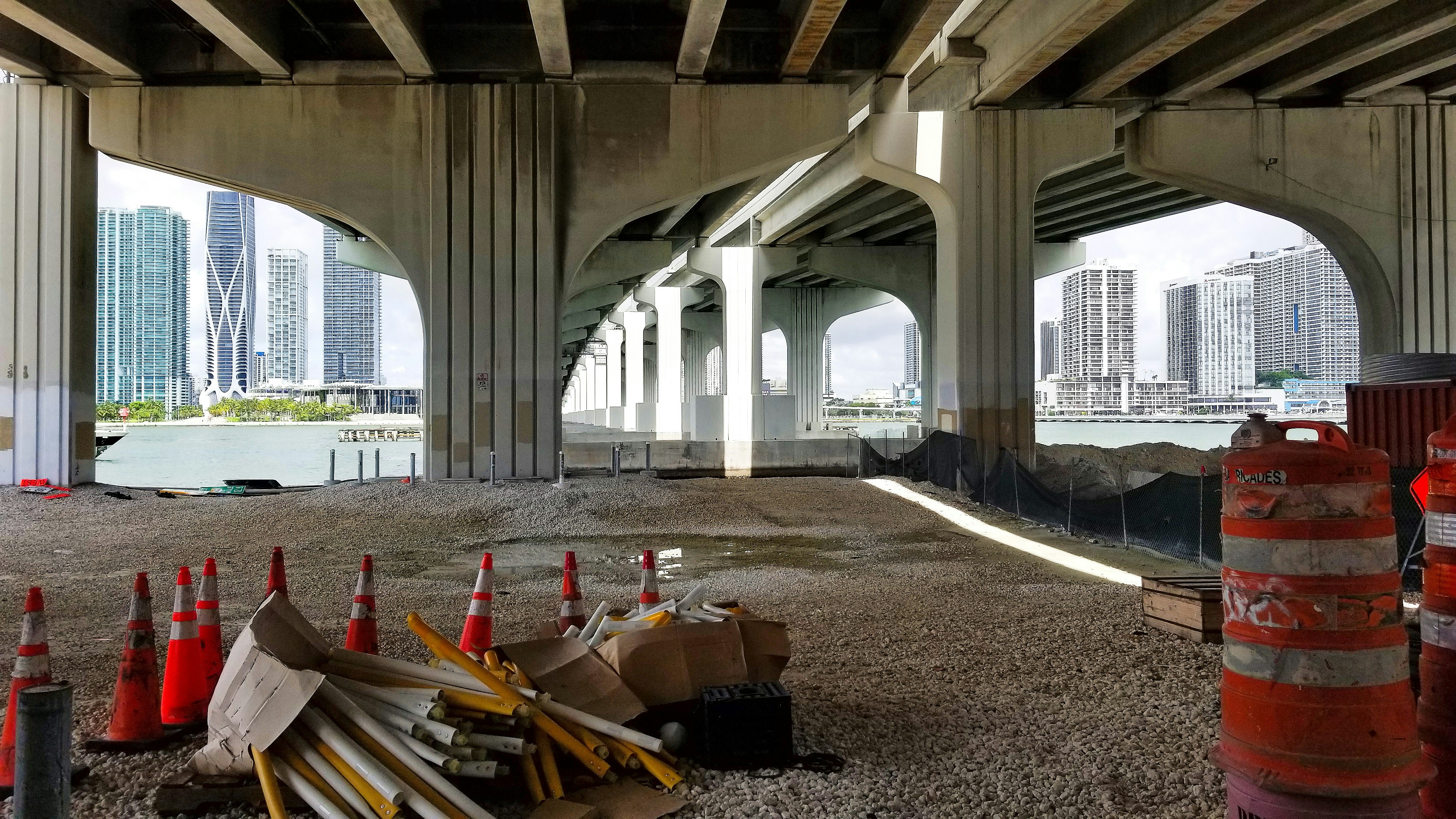 A construction site under a bridge with construction cones on the ...