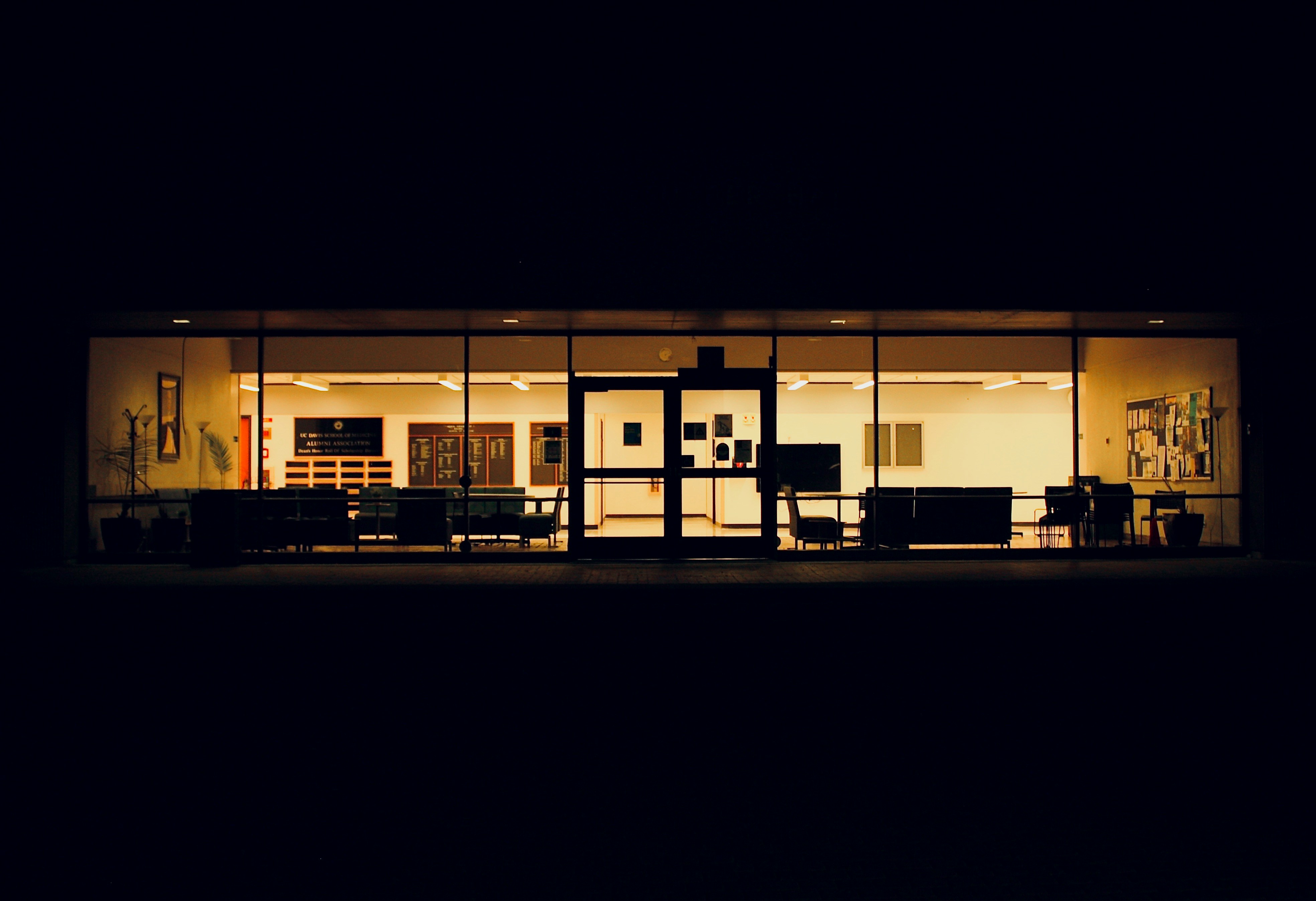 Illuminated office interior with yellow lighting against a dark exterior.