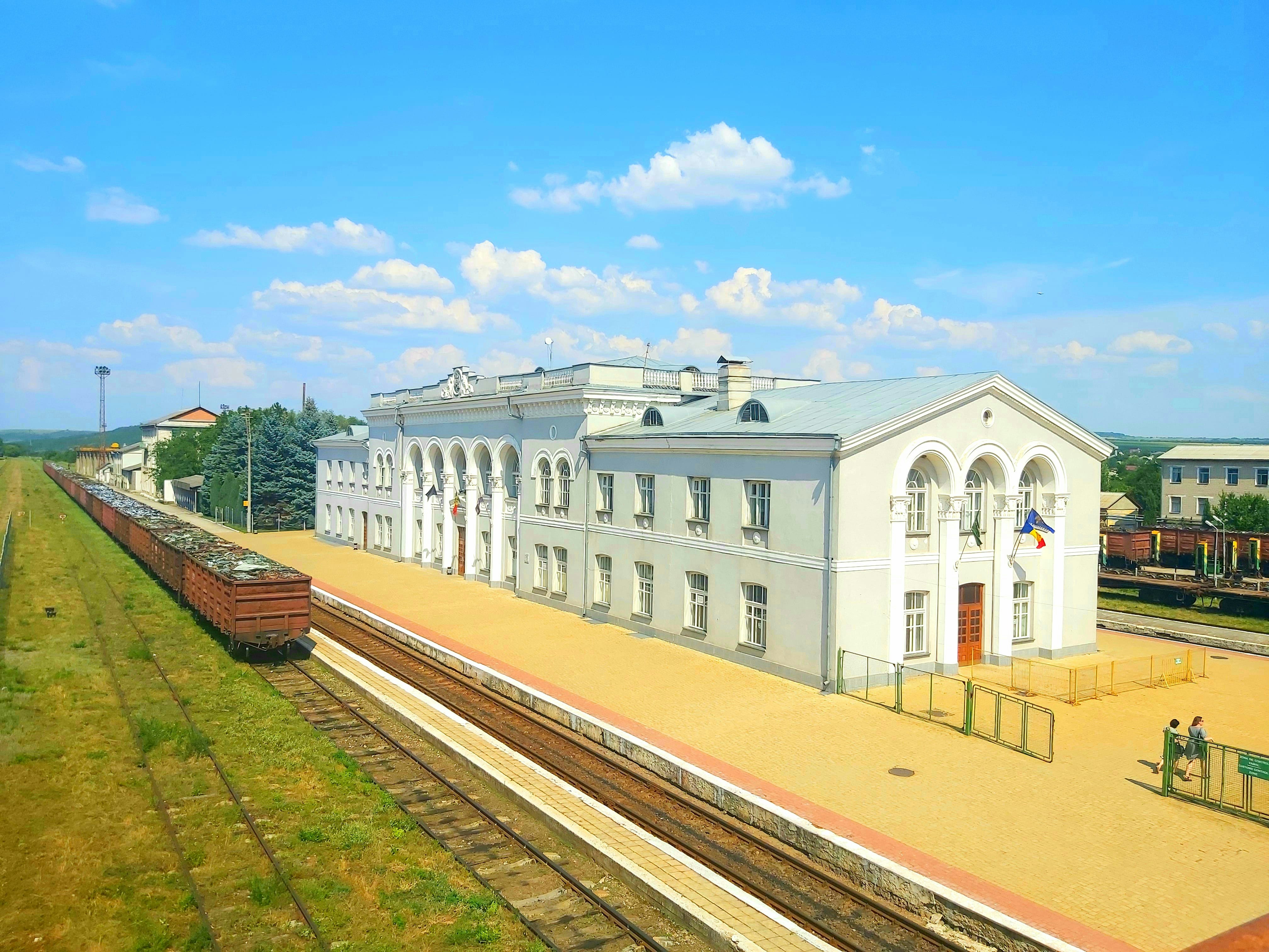 White and brown concrete building near train rail during daytime photo ...