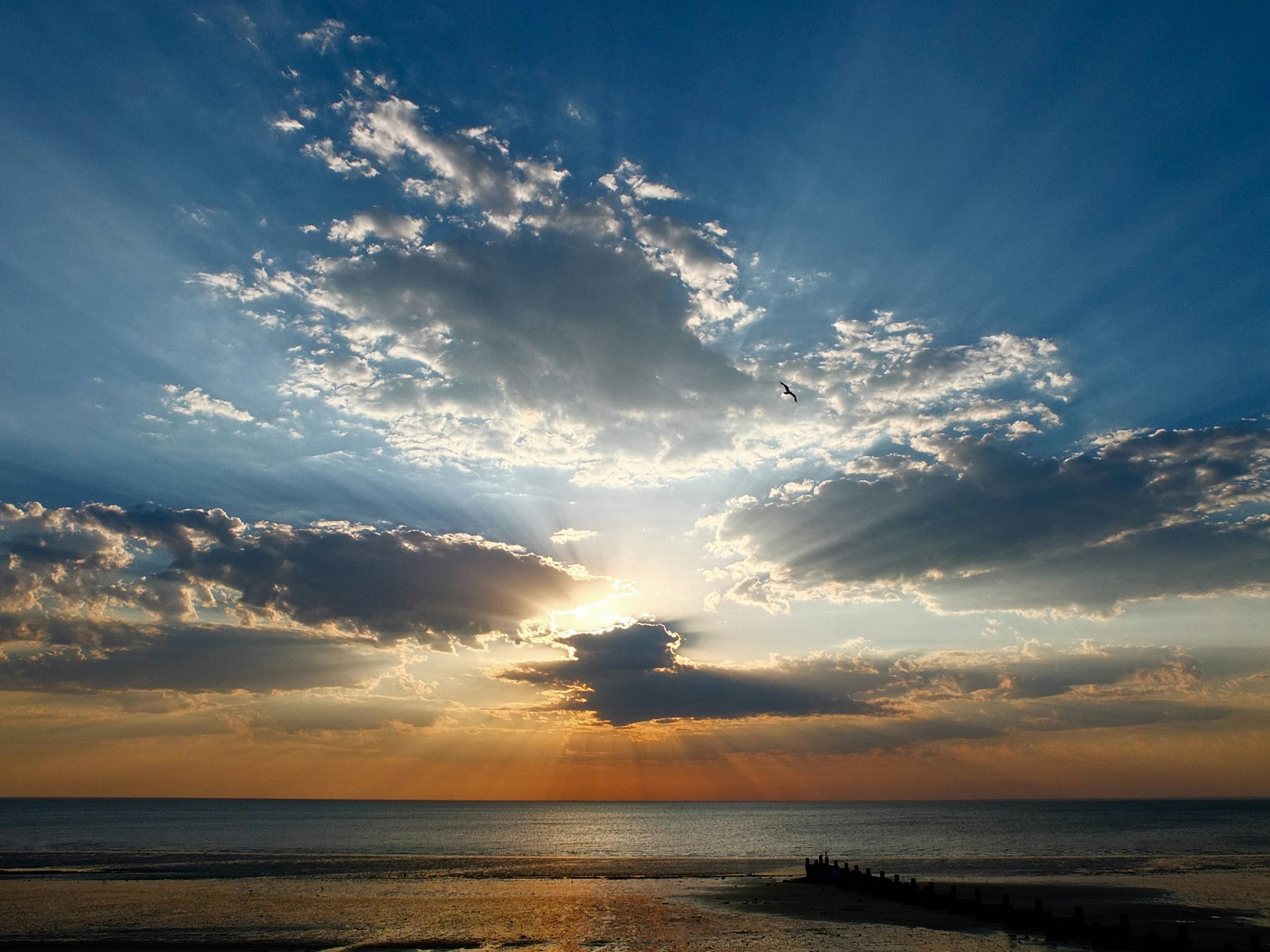 Sunburst on the Quiet Horizon: Clouds, Sea, and Warm Light