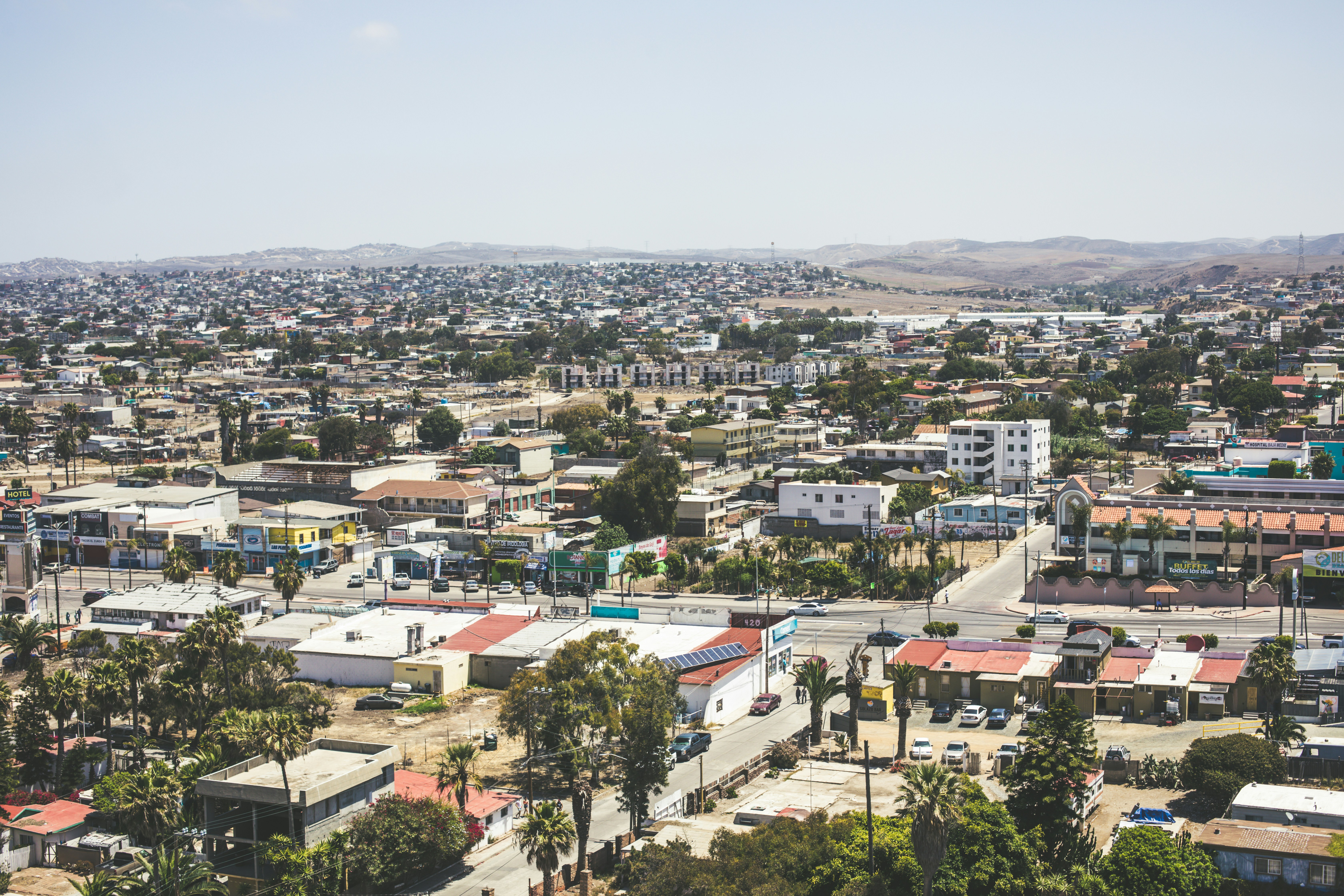 Aerial view of Rosarito showcasing urban buildings and distant hills under a clear sky.