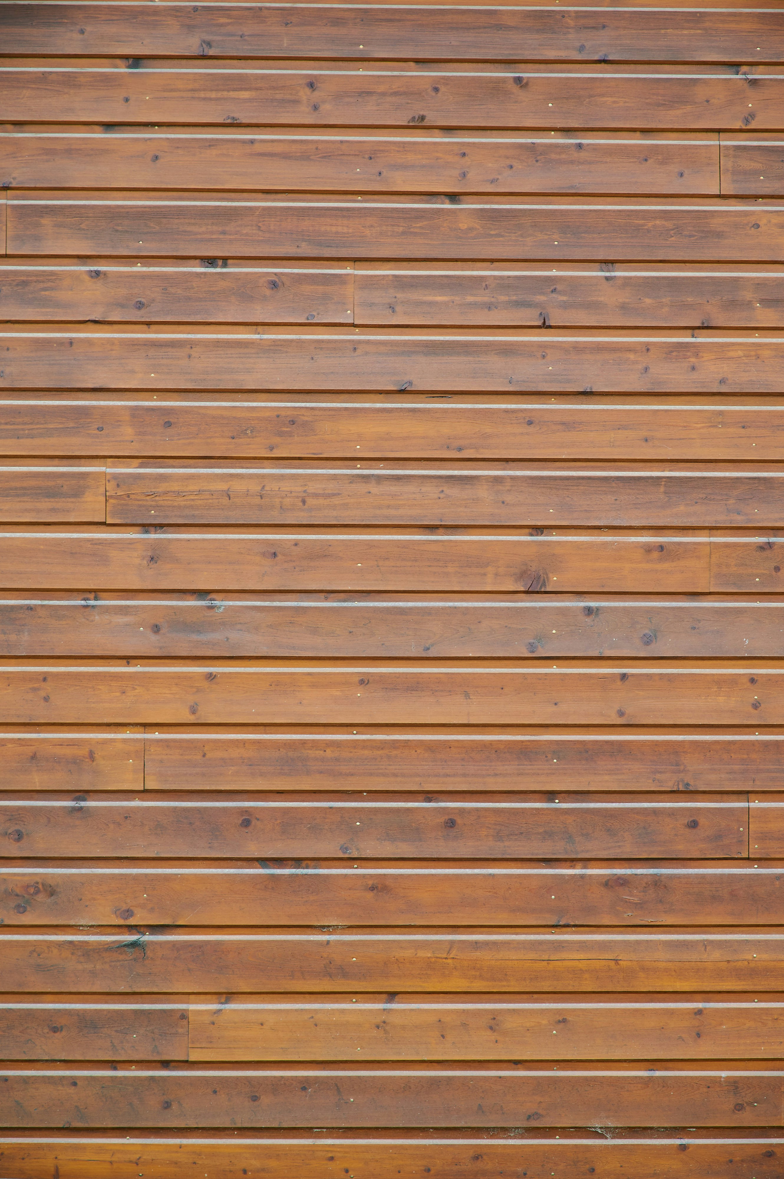 Close-up view of a wooden wall featuring horizontal planks with natural grain patterns and textures.