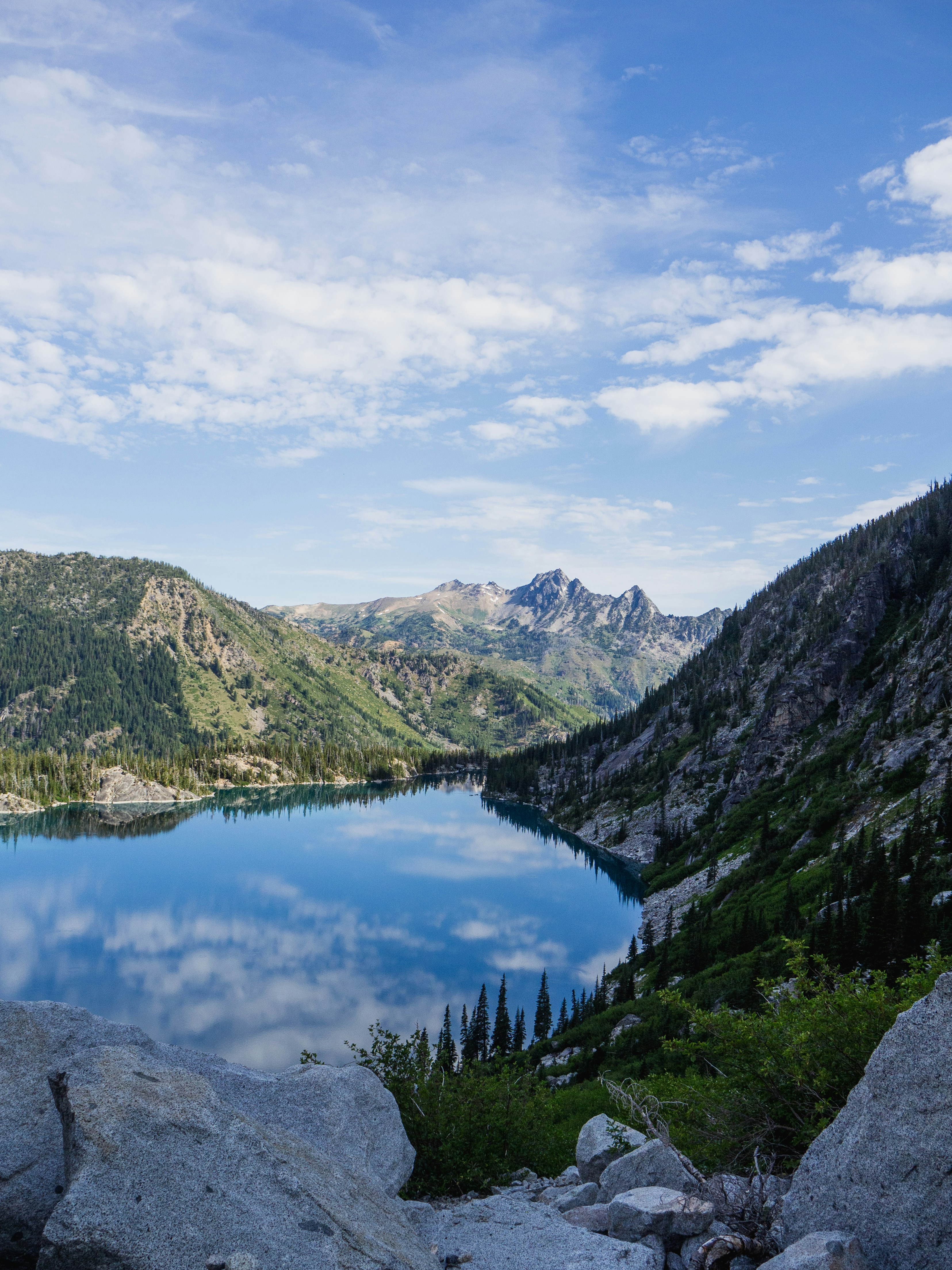 Foto Un lago azul rodeado de montañas bajo un cielo azul nublado ...