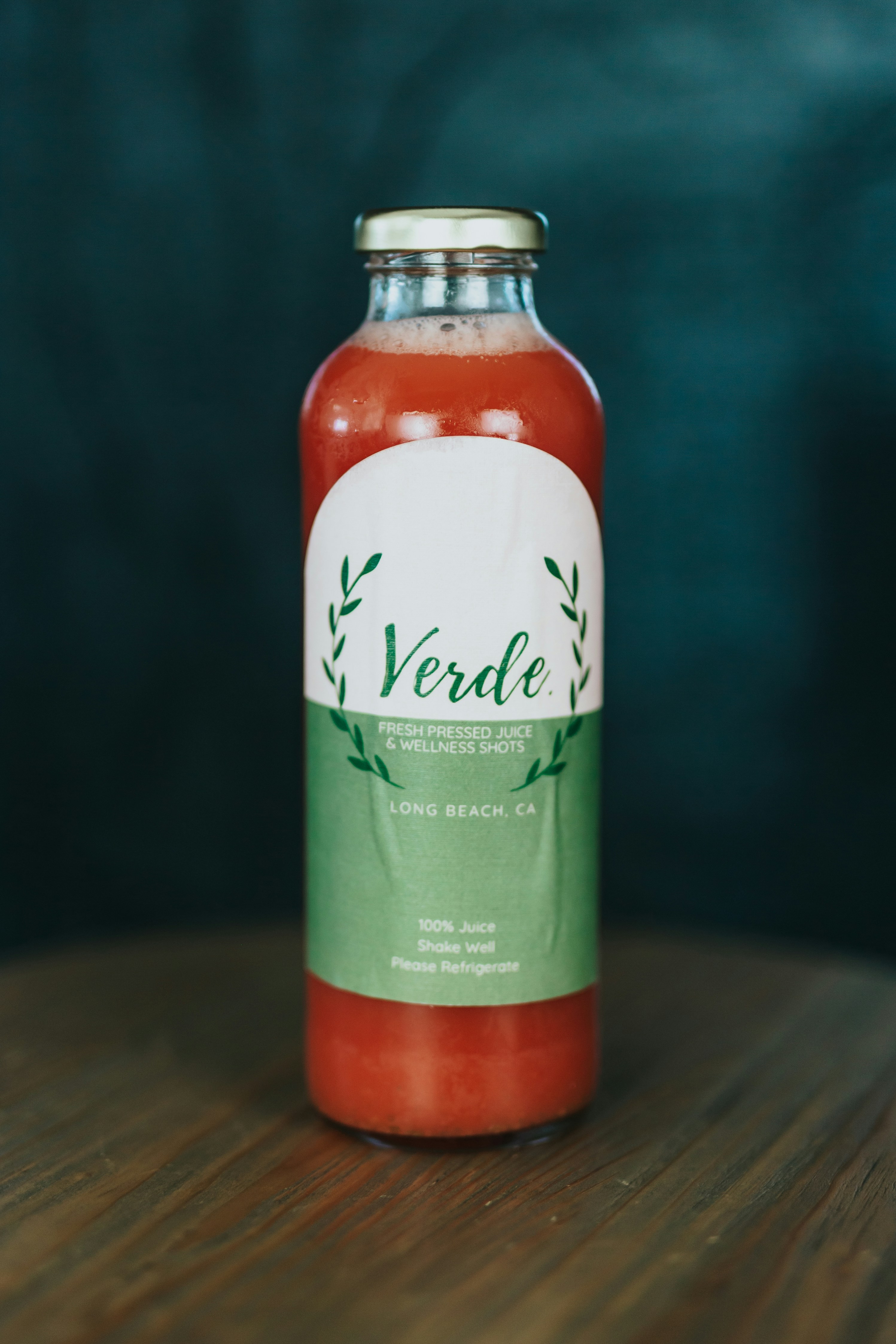 Verdé on Wood: Emerald-Label Juice Bottle in a Quiet Studio