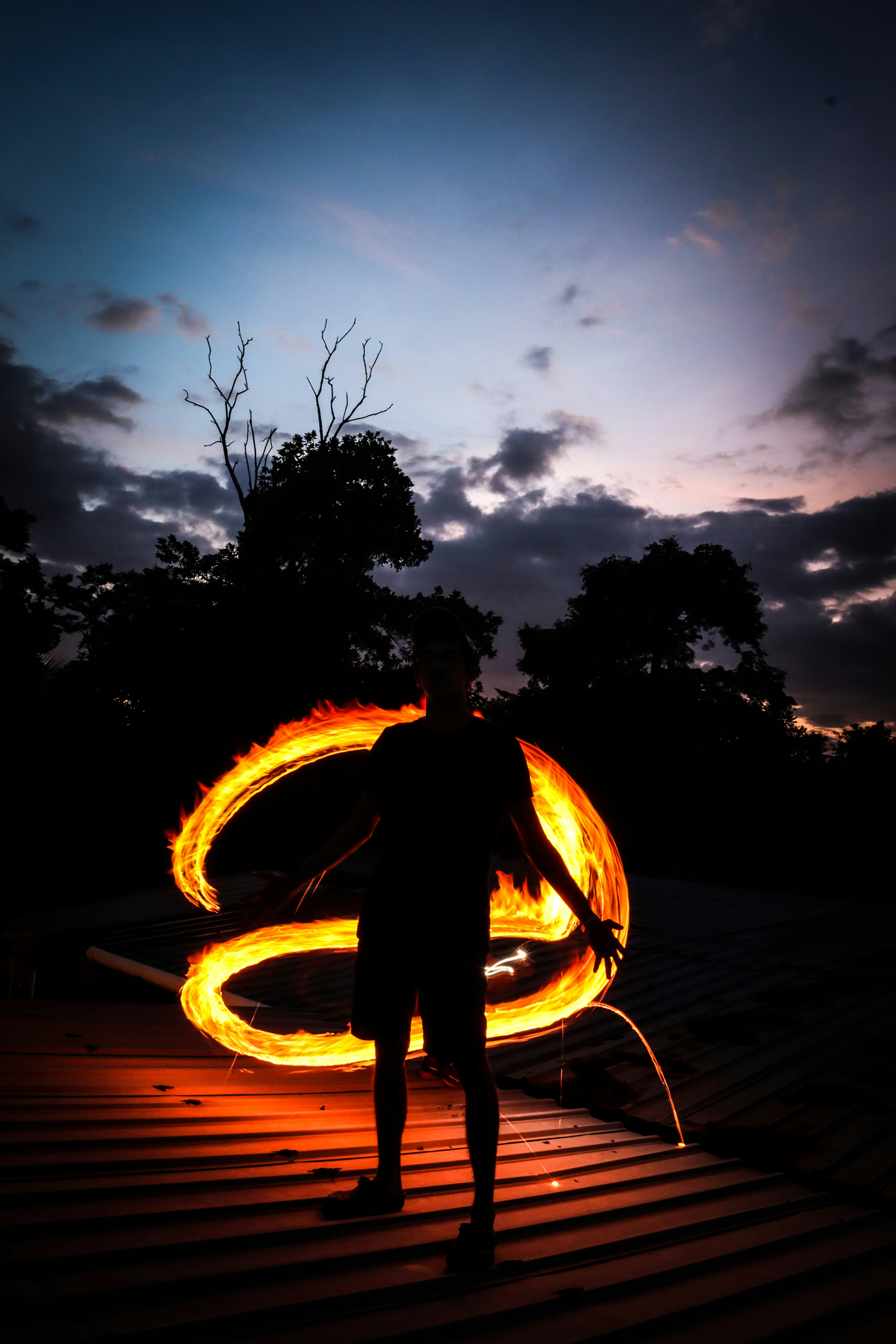 Rings of Ember: Rooftop Fire Poi Silhouette at Twilight