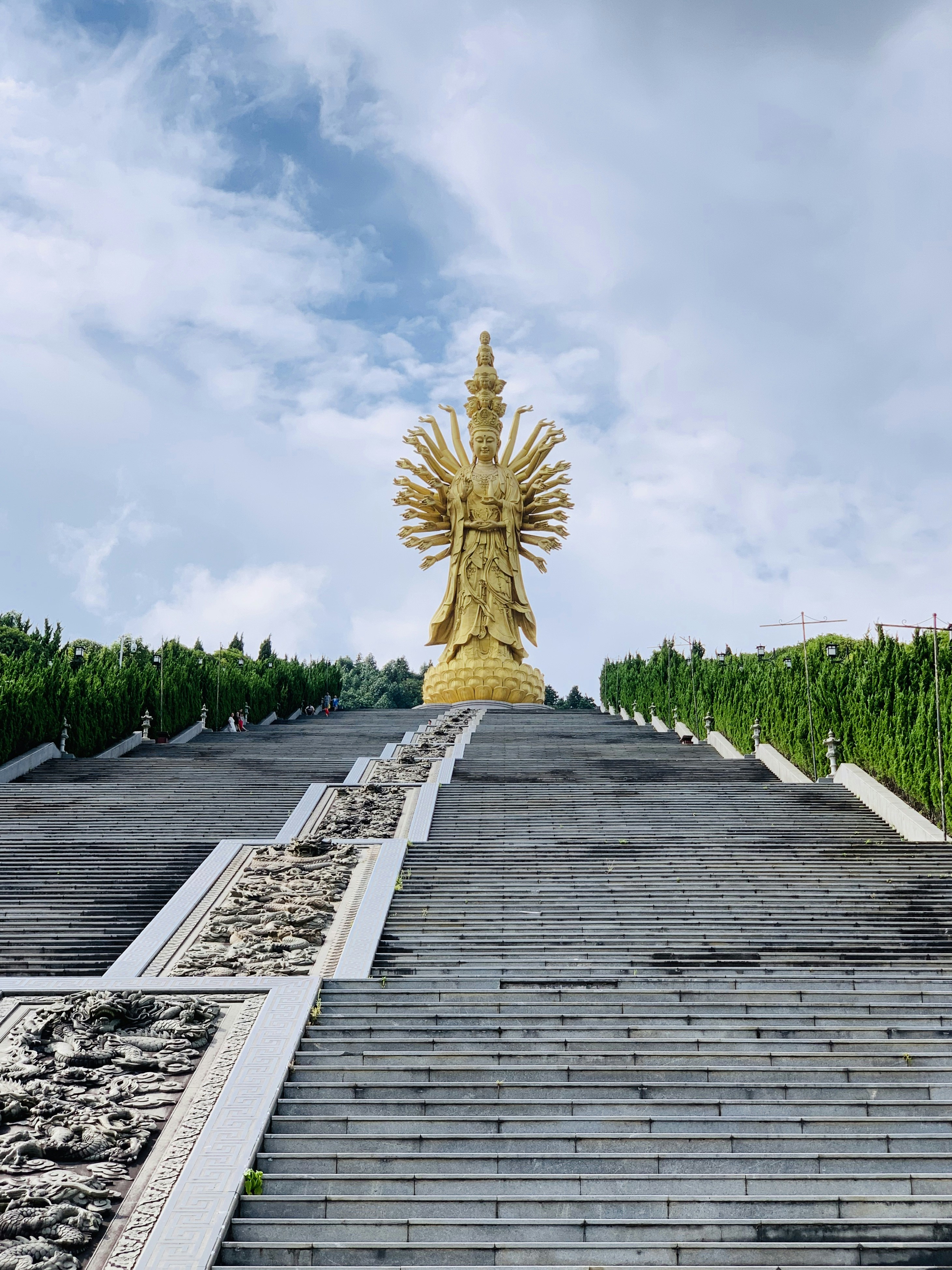 gold statue on wooden dock under cloudy sky during daytime