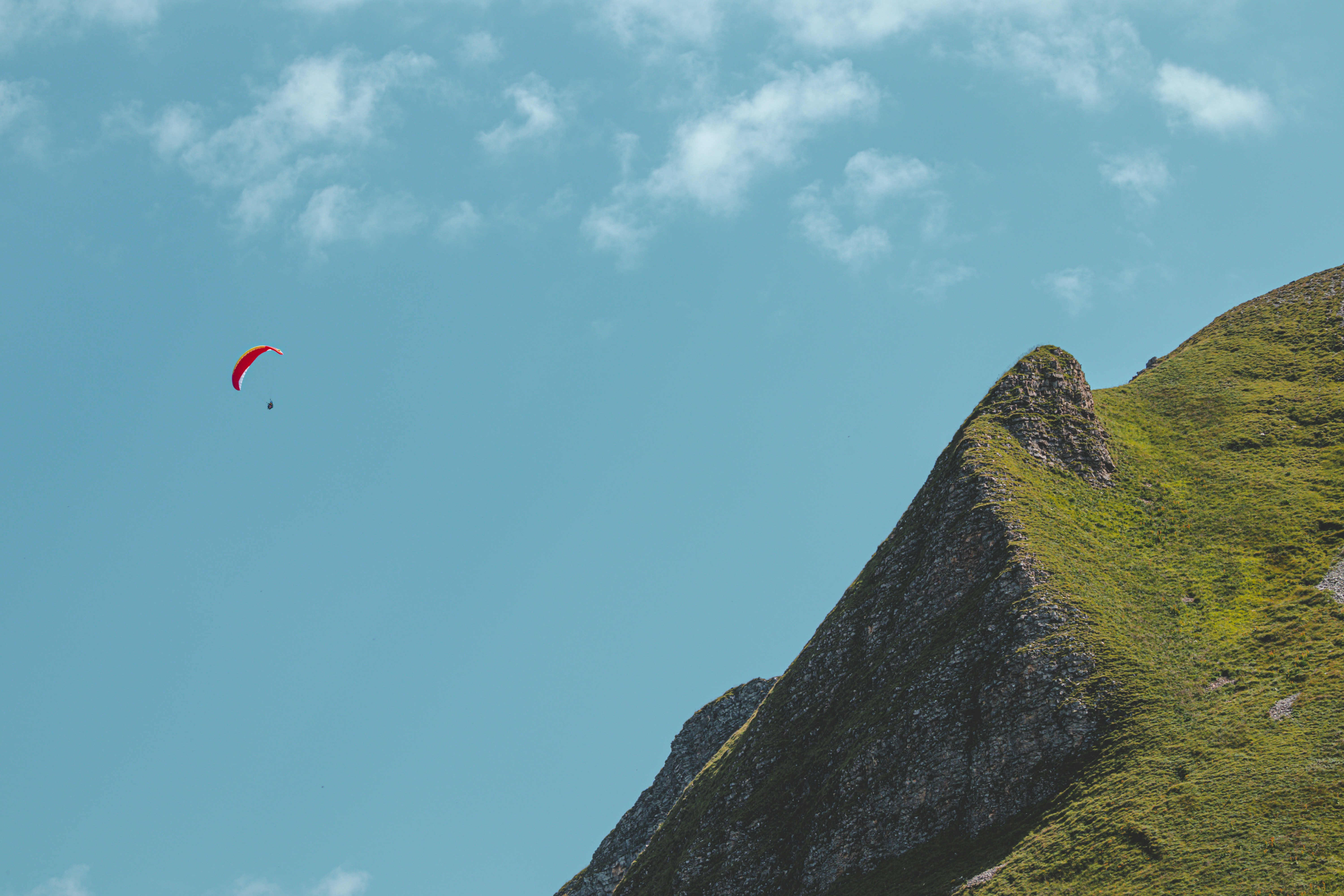 A Lone Paraglider Against a Rugged Mountain CrestMarco Pregnolato