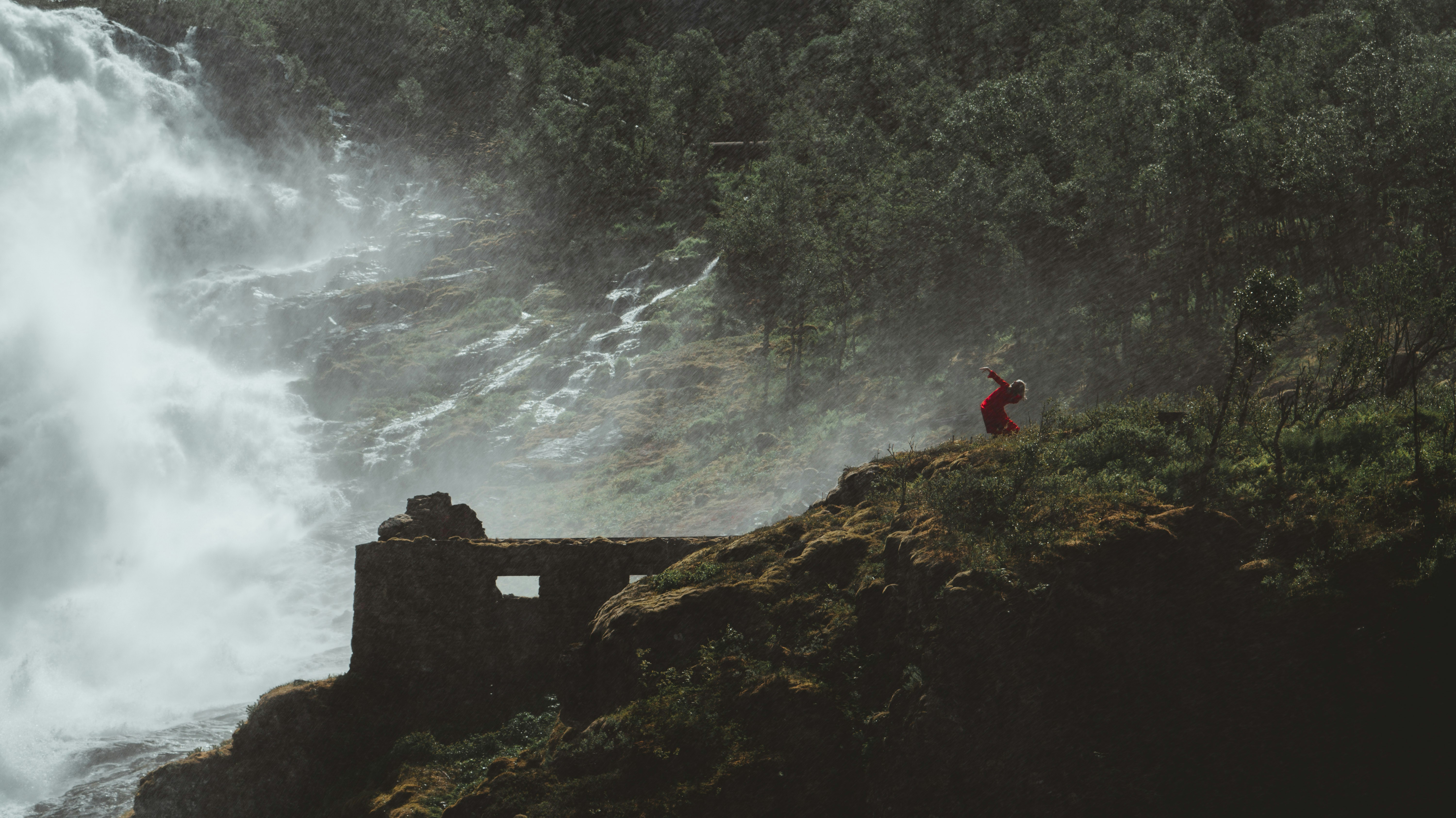 Crimson on the Crest: A lone figure above the roar