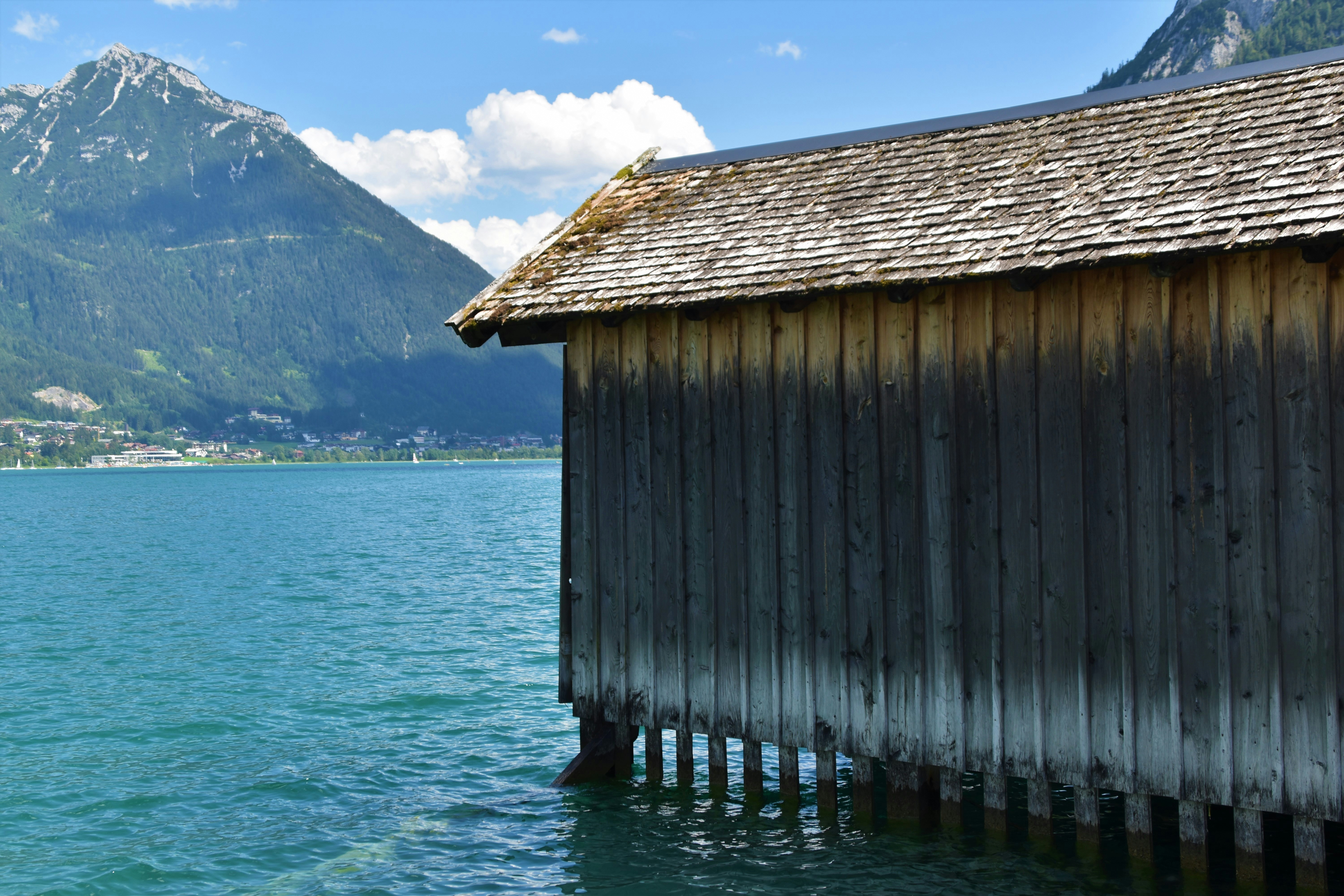 Weathered Boathouse Framed by a Turquoise Alpine Lake and Towering Peaks