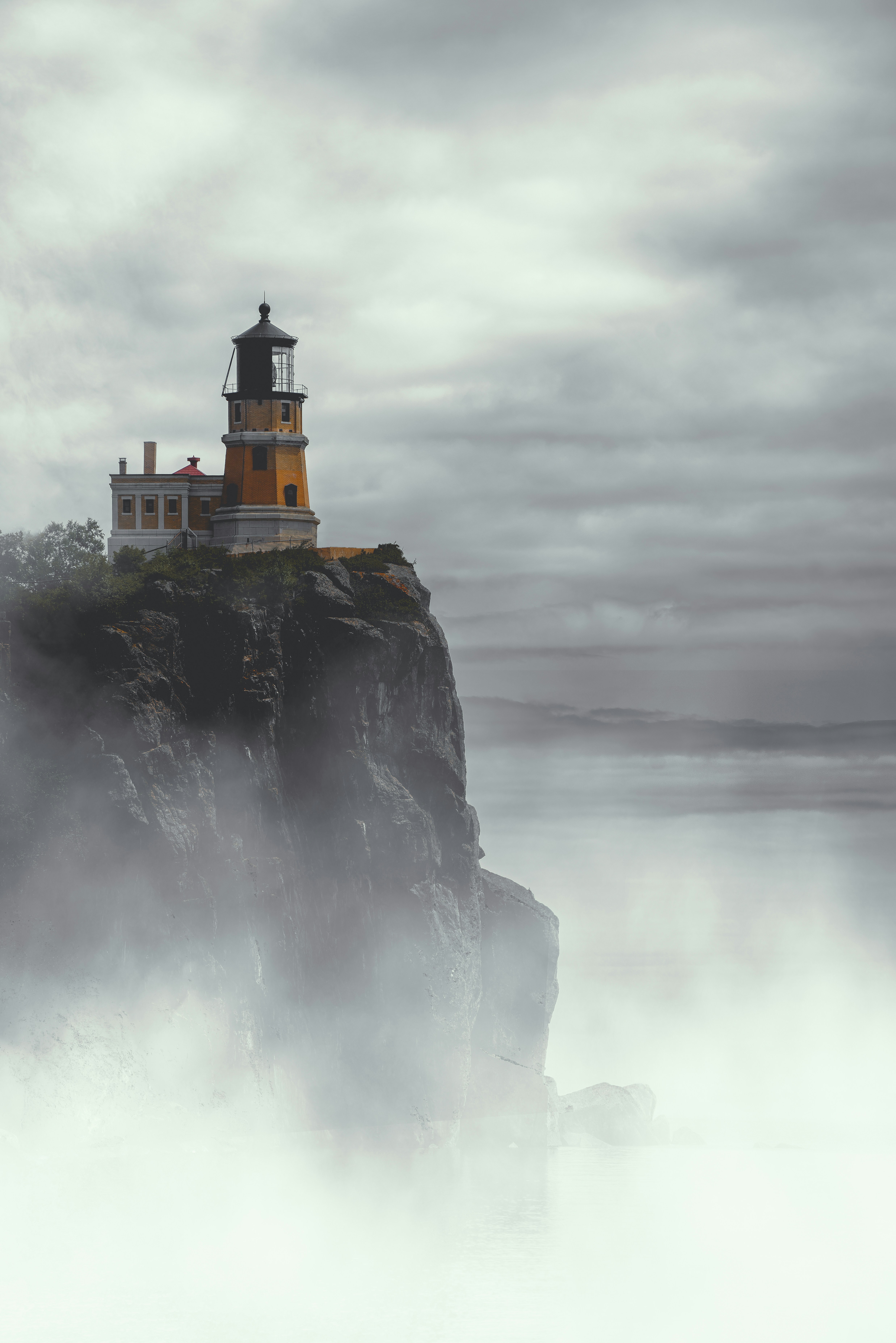 My son and I got up early and hiked several miles to capture this shot on the shores of Lake Superior.   | white and brown concrete building on top of brown rock mountain