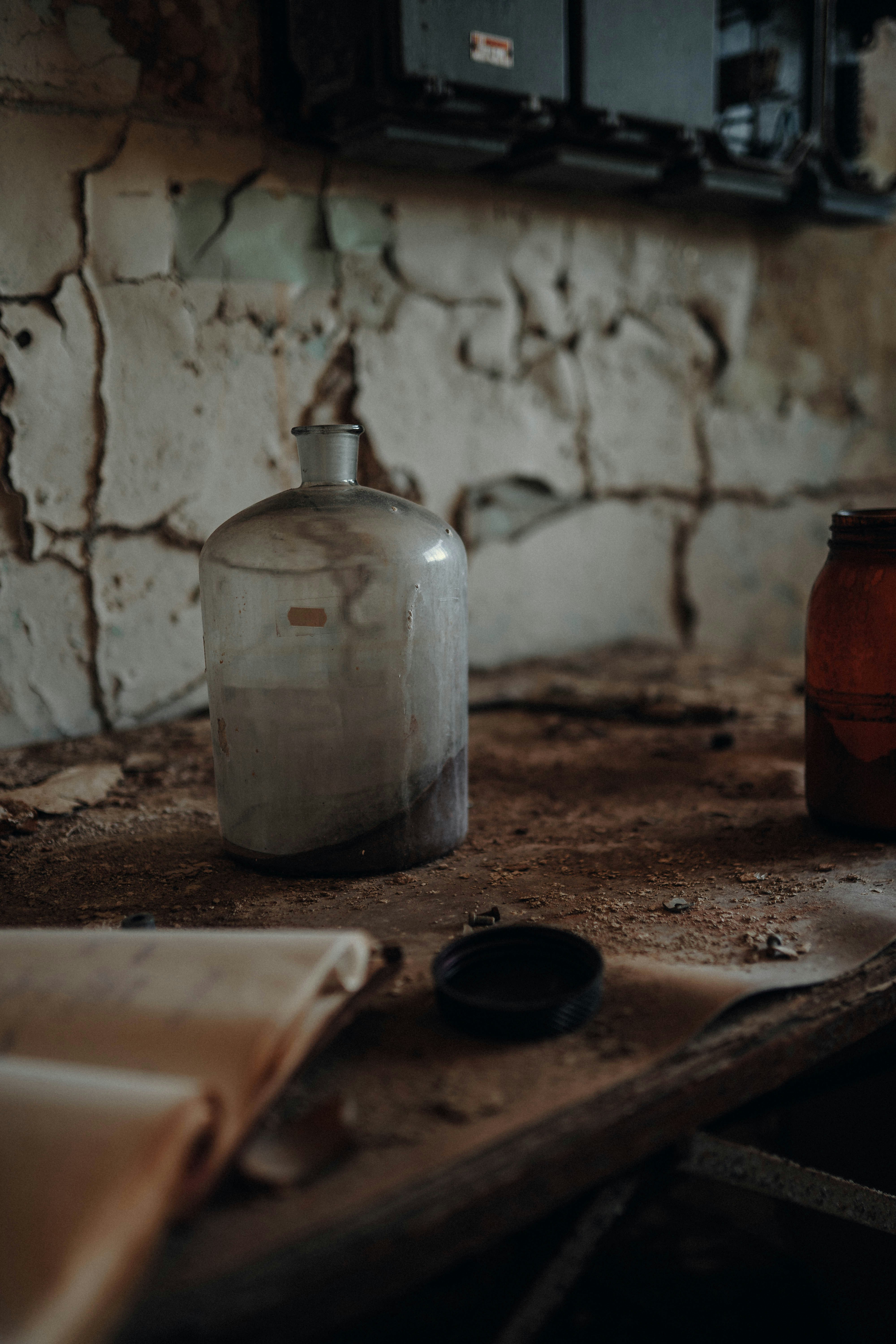 Dusty Bottles and Quiet Machinery in a Rusted Workbench