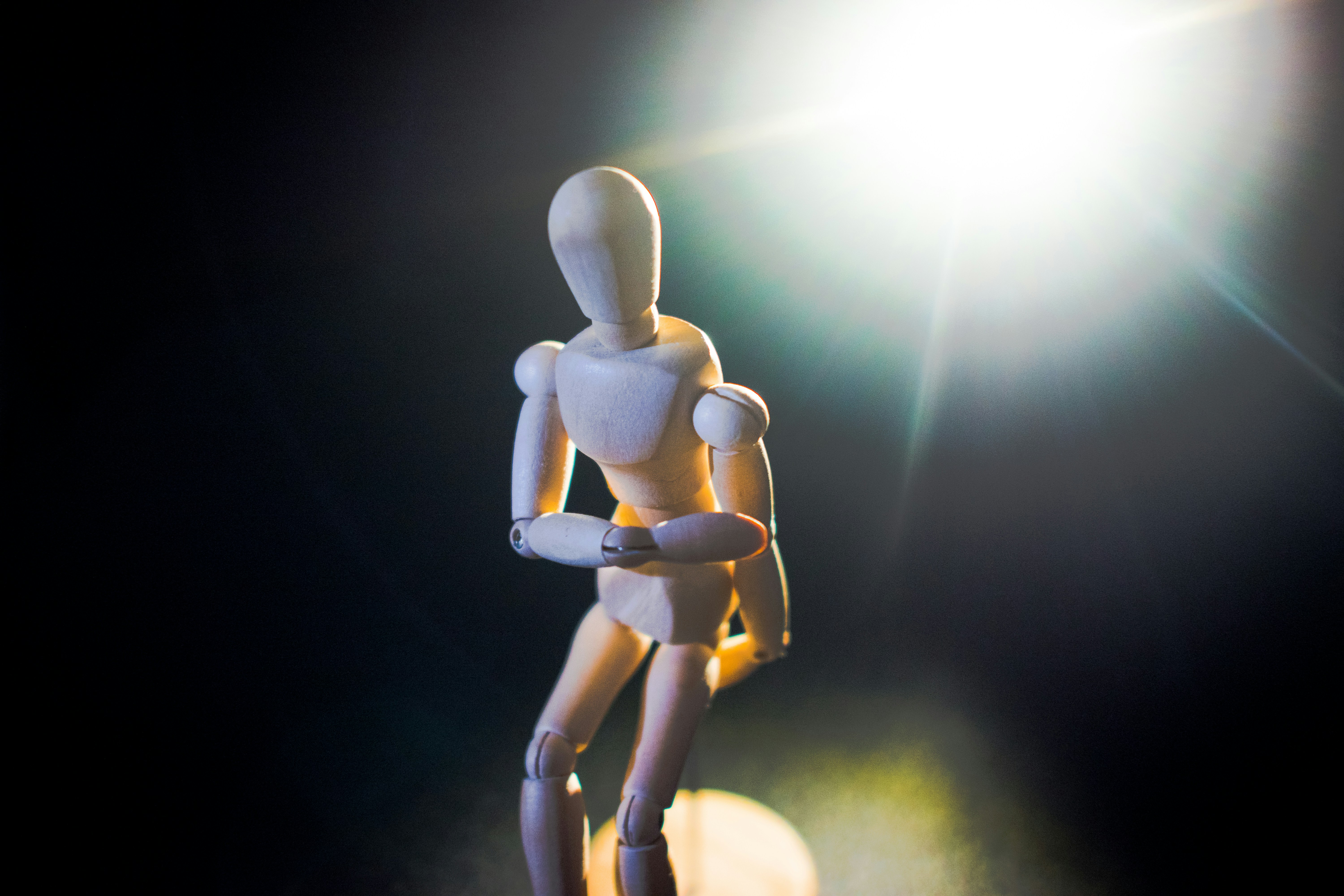 Illuminated Figure: A Wooden Model Under a Harsh Spotlight
