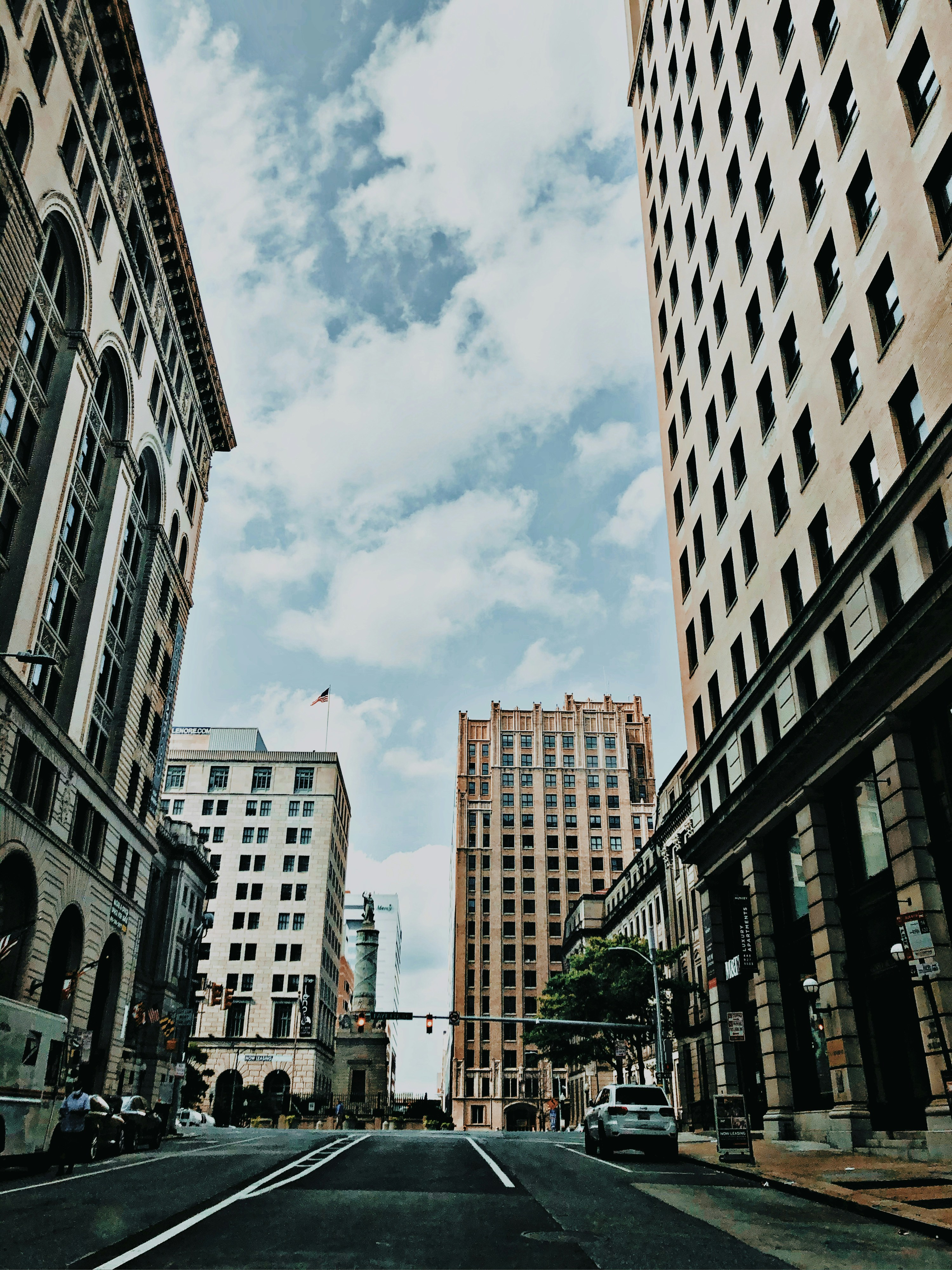 Street of downtown Baltimore. | white and brown concrete building under white clouds during daytime