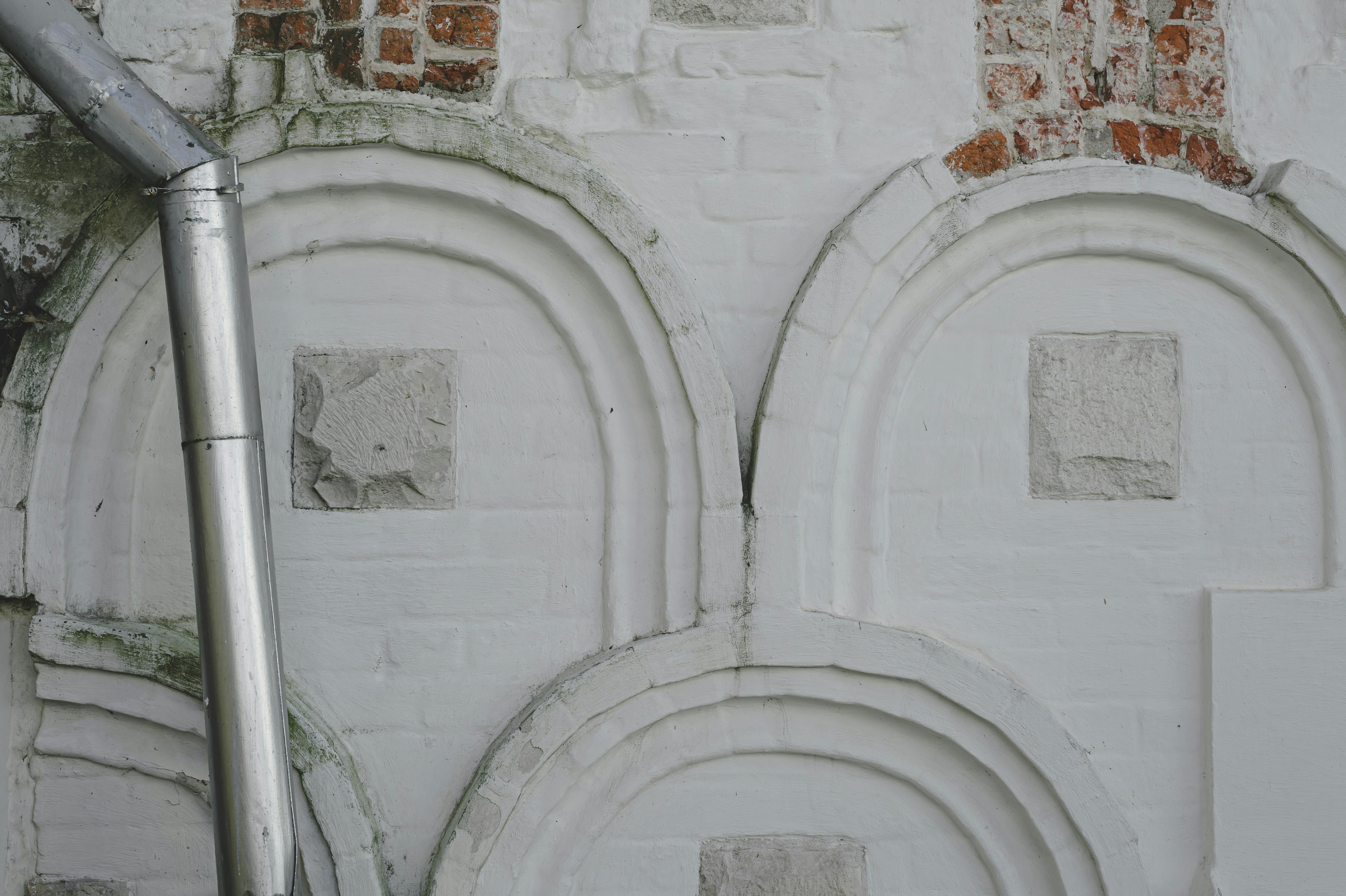 Echoes of Concentric Arches on a Weathered White Wall