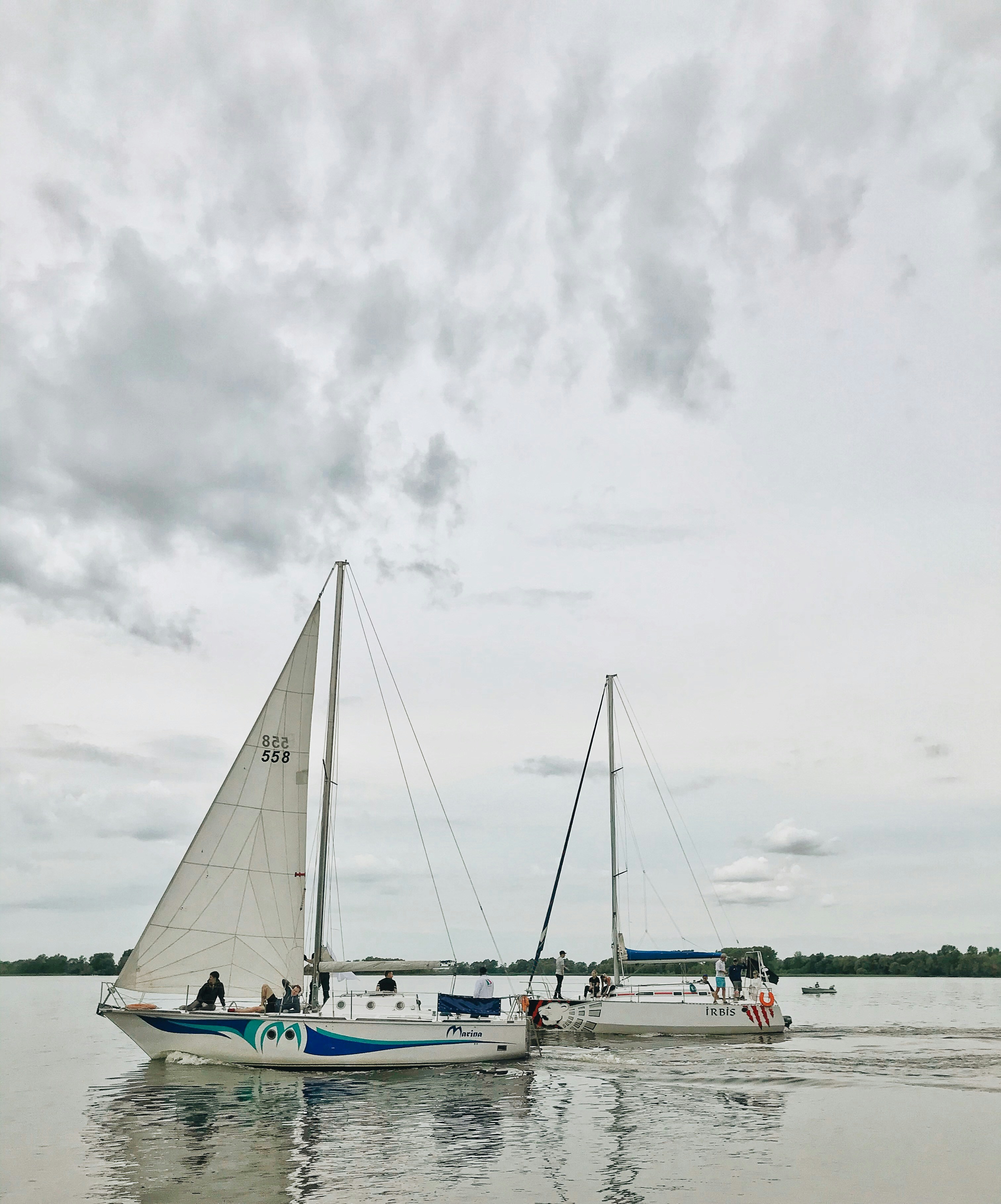 Twin Sails Across a Gray-Washed Lake Under Quiet Skies