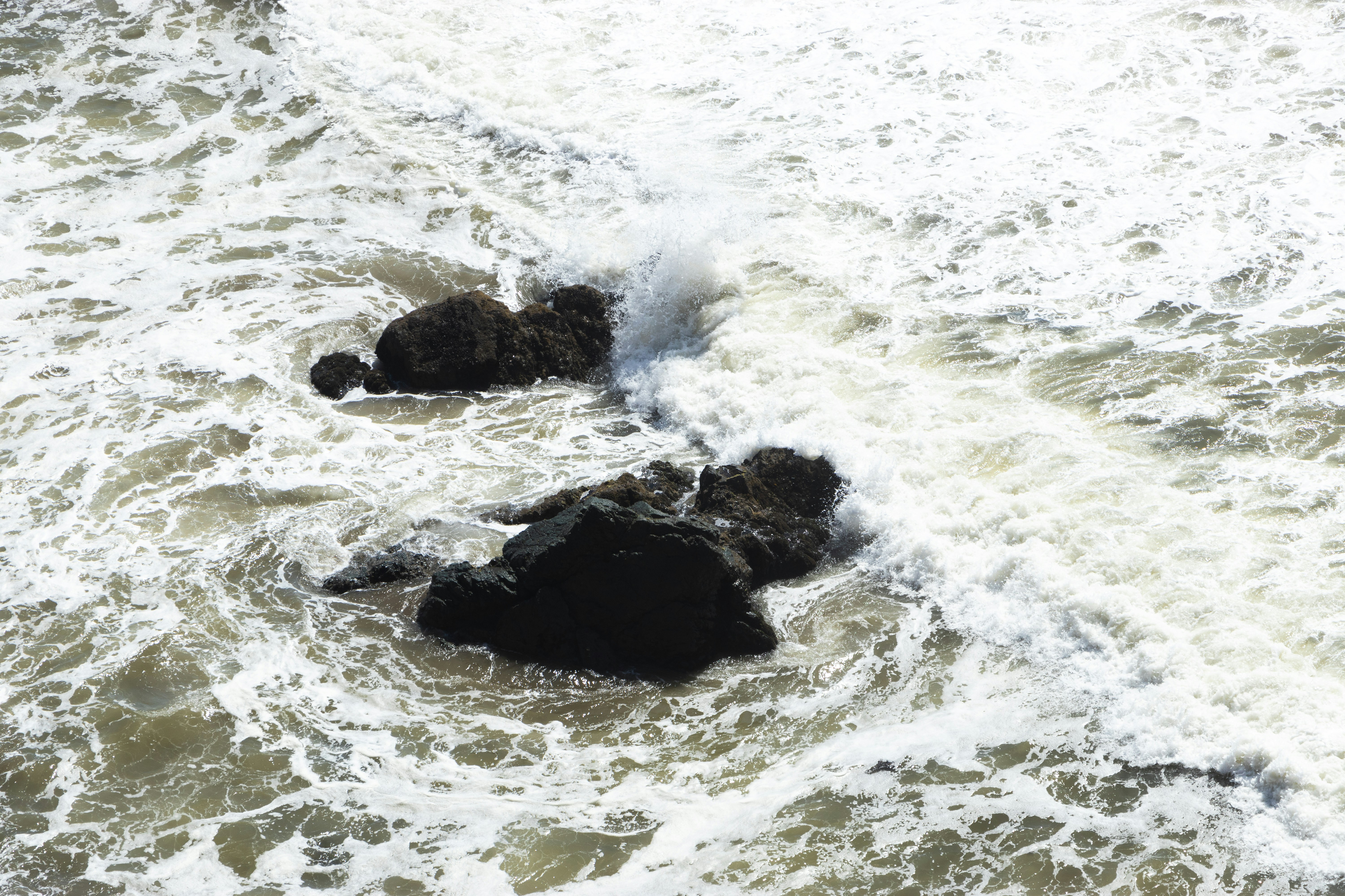 Black rock formation on body of water during daytime photo – Free Black ...