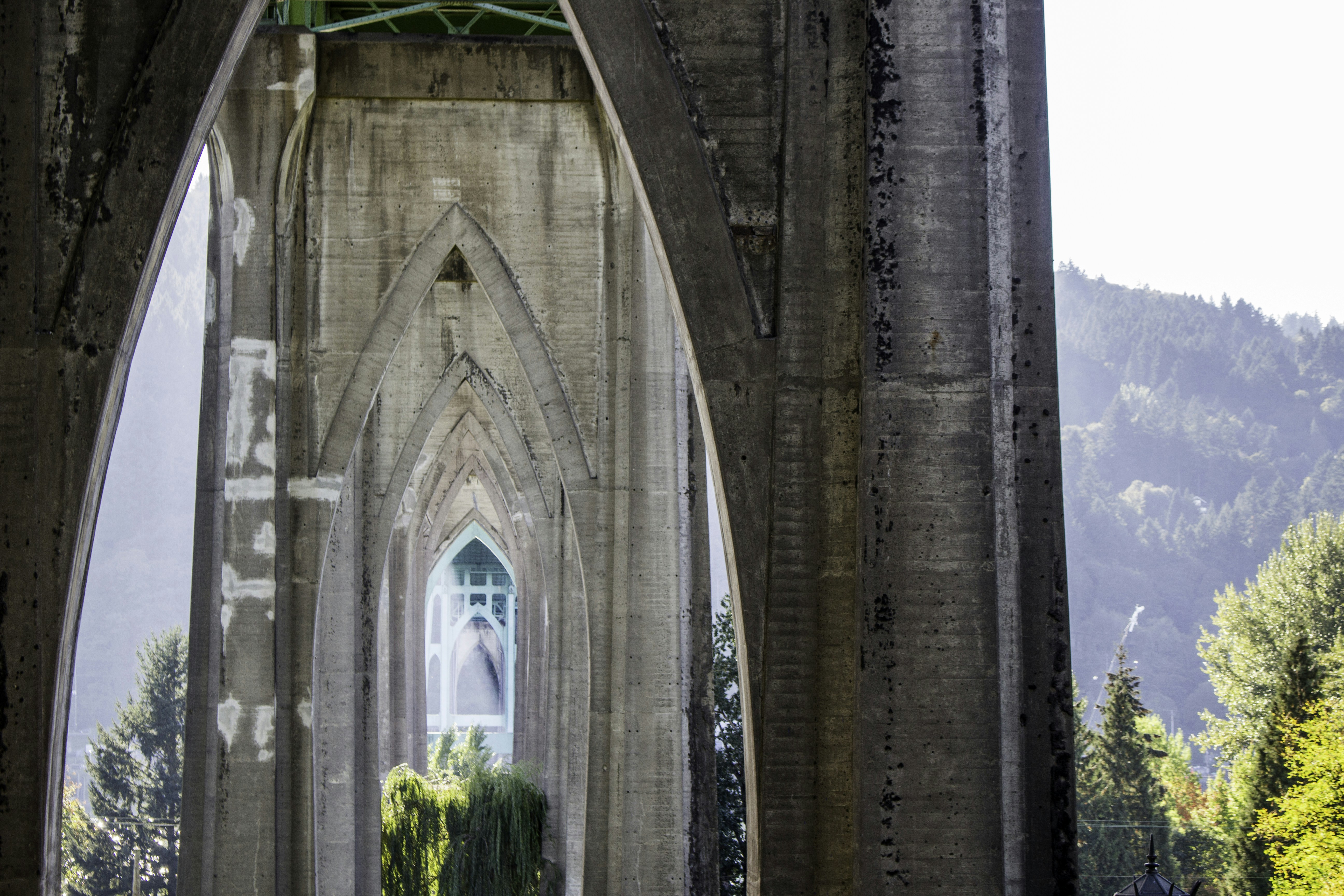 Between Concrete Arches: A Distant Light-Window Framed by Monolithic Pillars