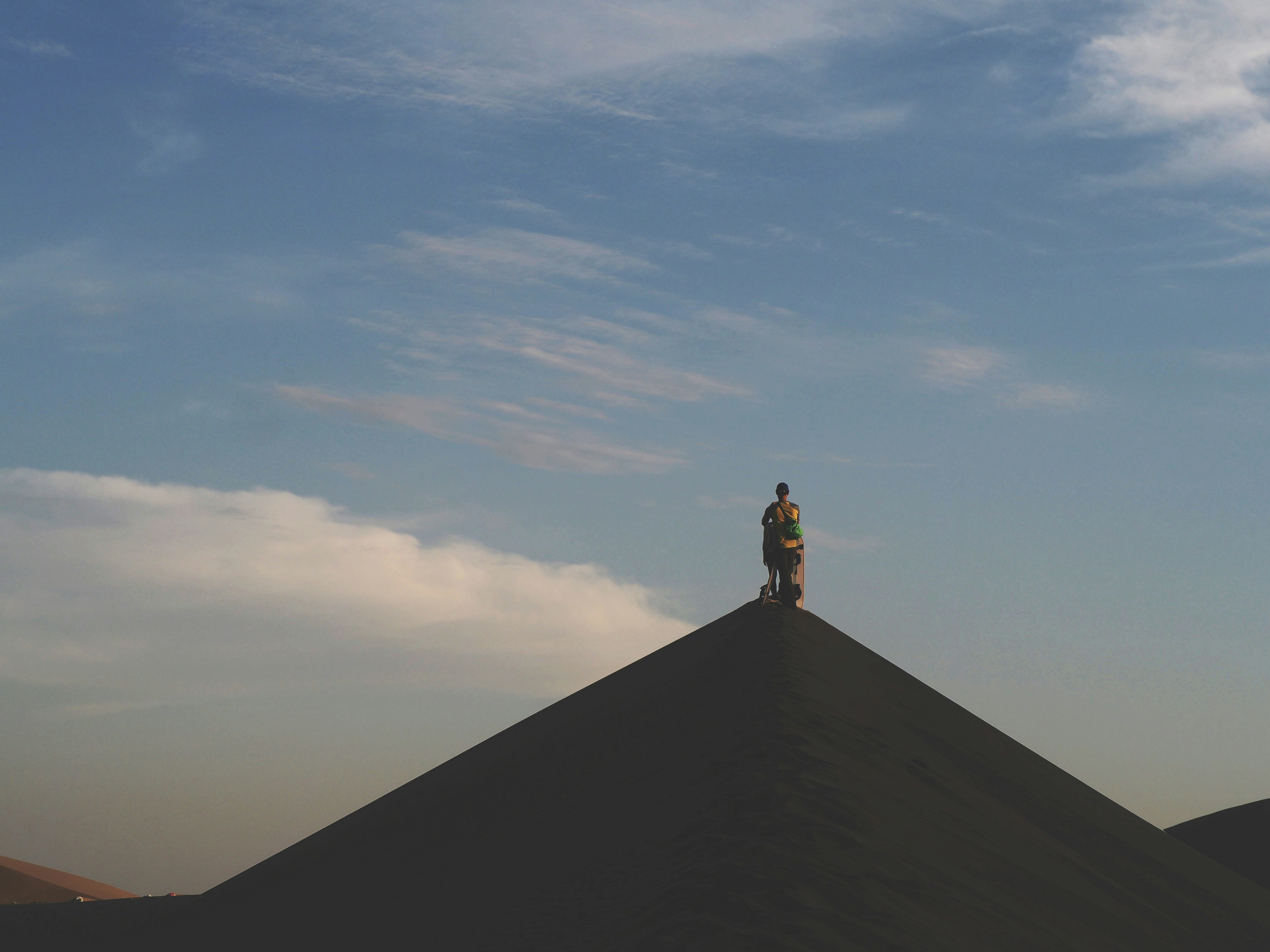 Crest of Solitude: A climber at the dune’s apex
