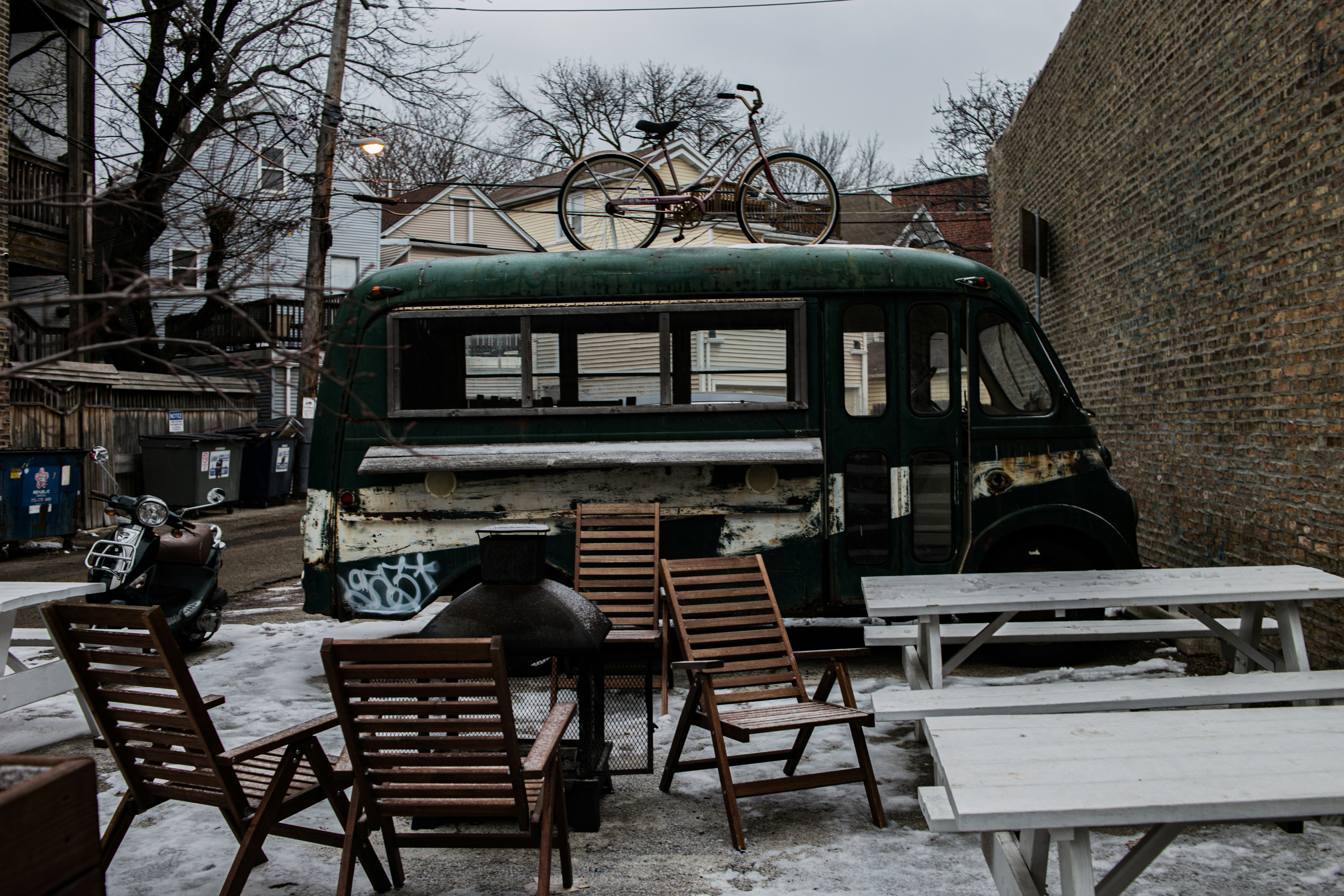 Bike on a Weathered Van Over a Snowy Urban Courtyard