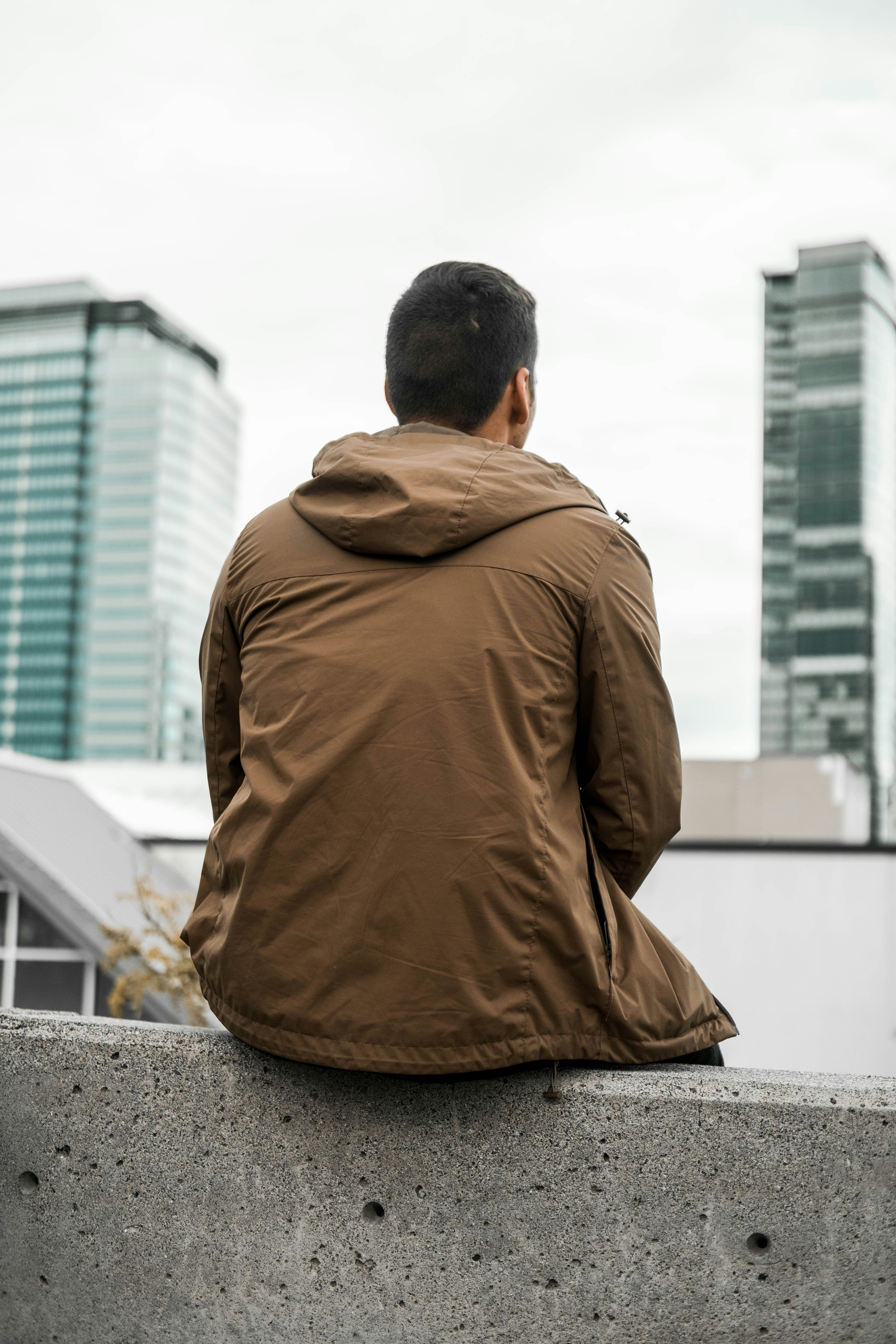 Rooftop Quiet: A Brown-Jacket Moment Between Skyline and Concrete